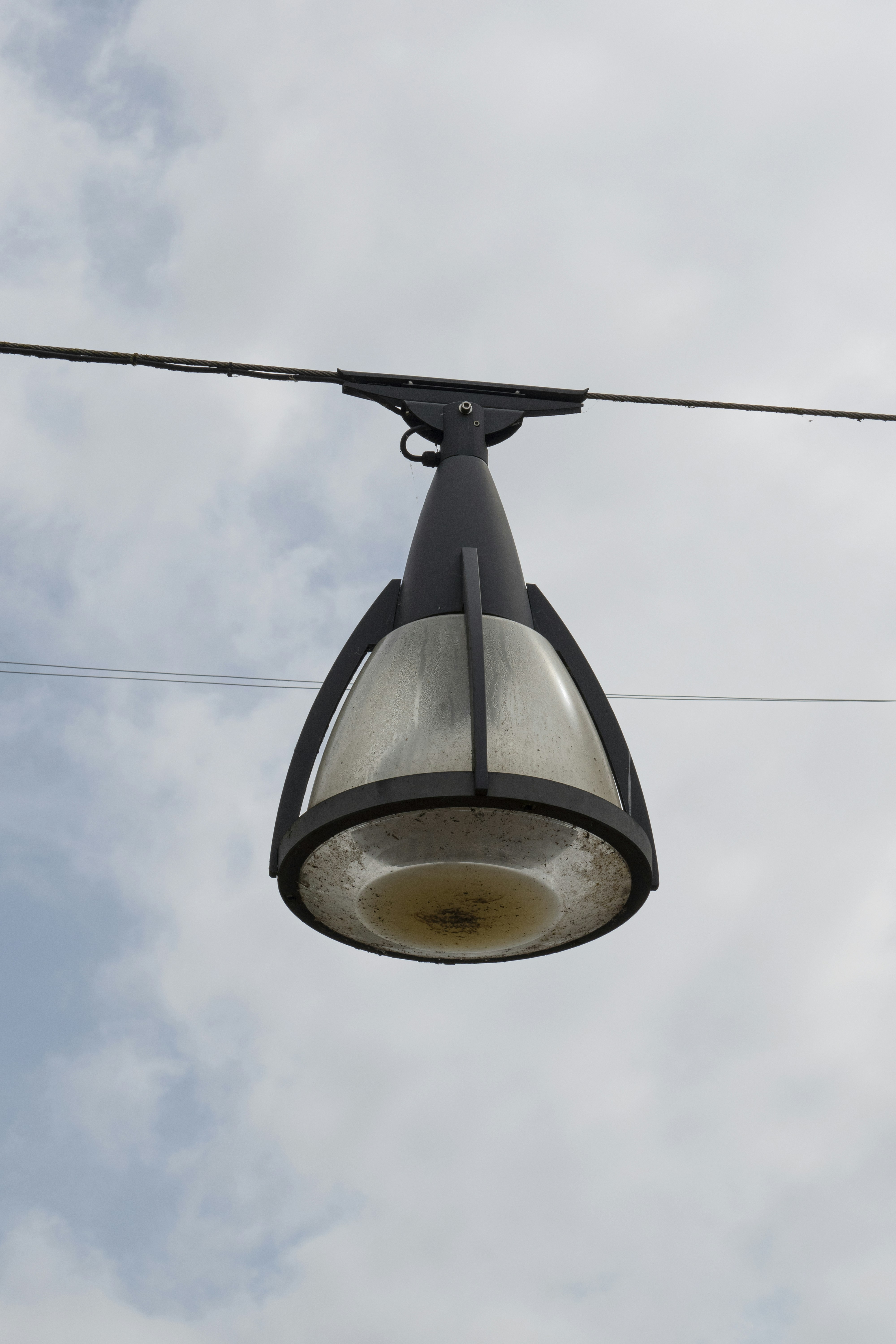 Suspended Lantern: Geometry of a Streetlamp Against a Clouded Sky