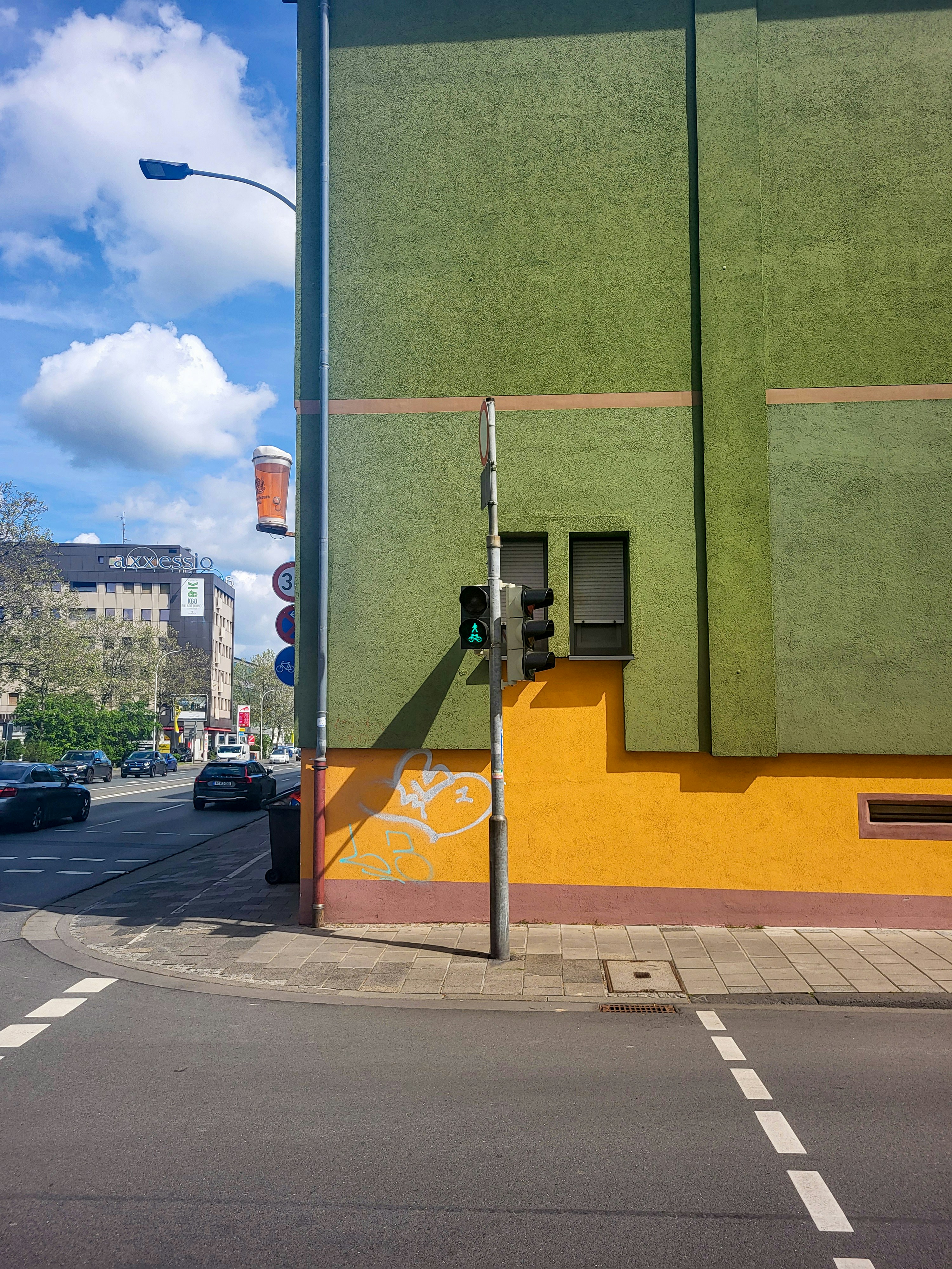 A street corner with a green building and a street light photo – Free ...