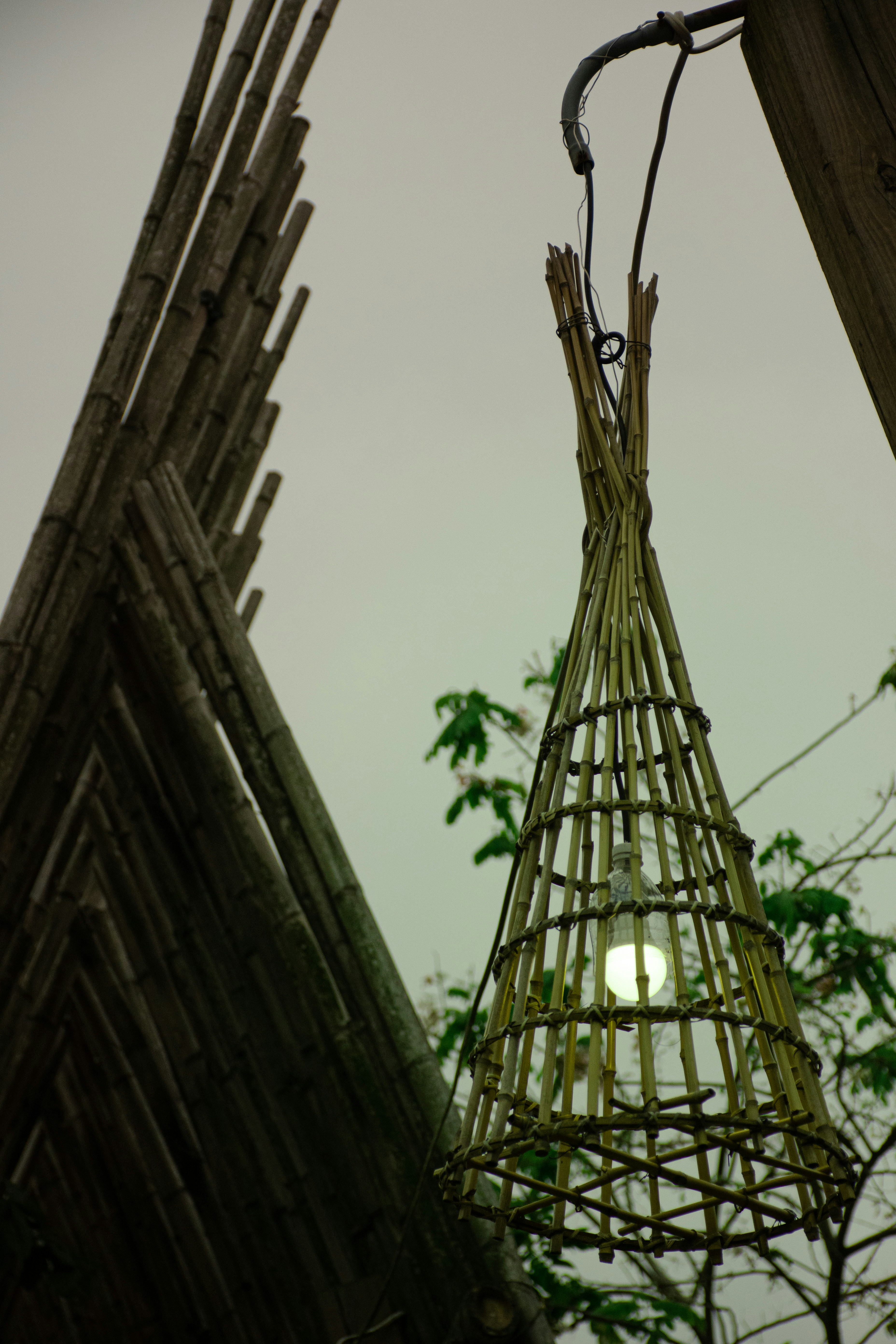 Hanging Bamboo Lantern Framed by a Weathered Thatch Roof