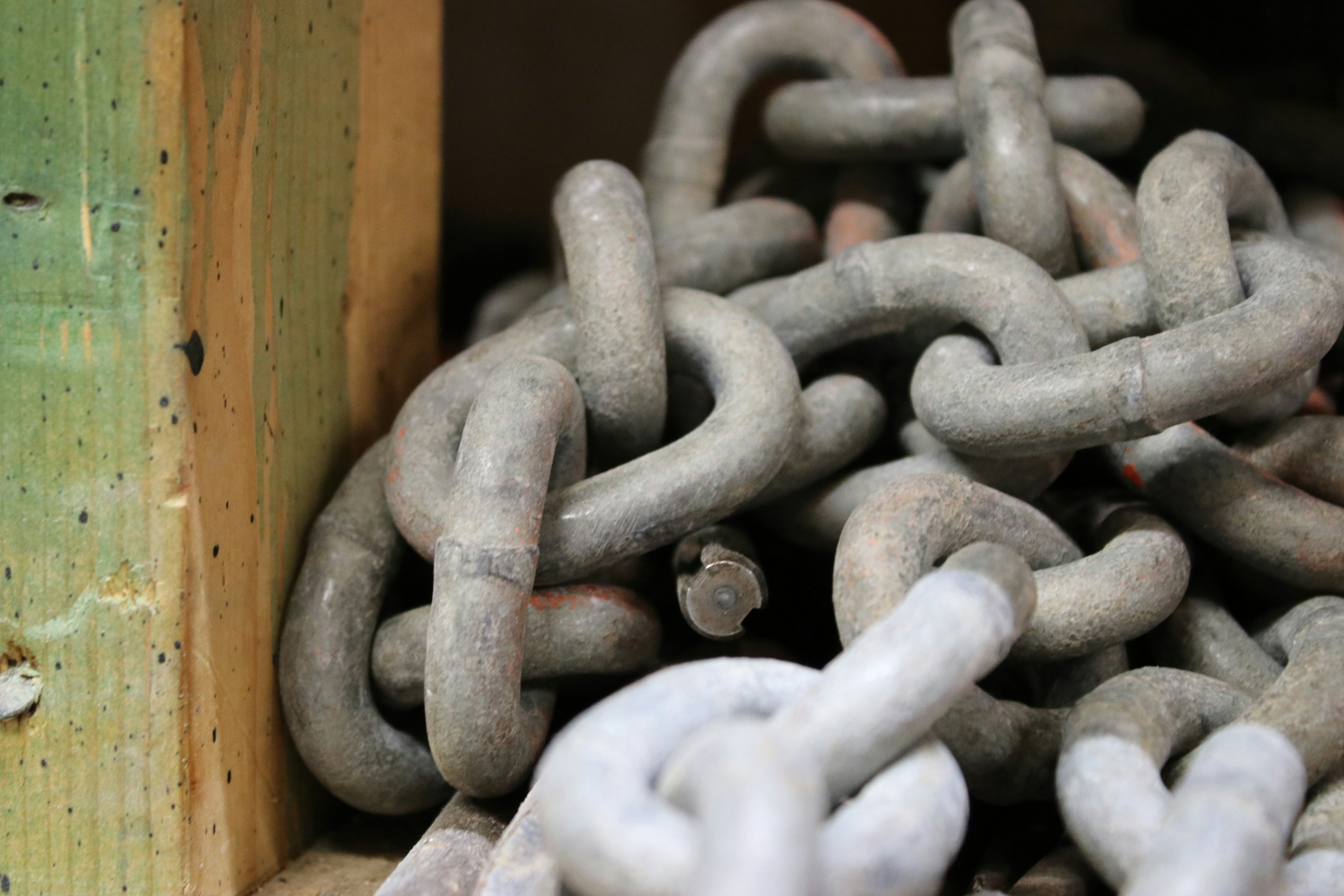 A pile of metal chains sitting on top of a wooden box photo – Free ...
