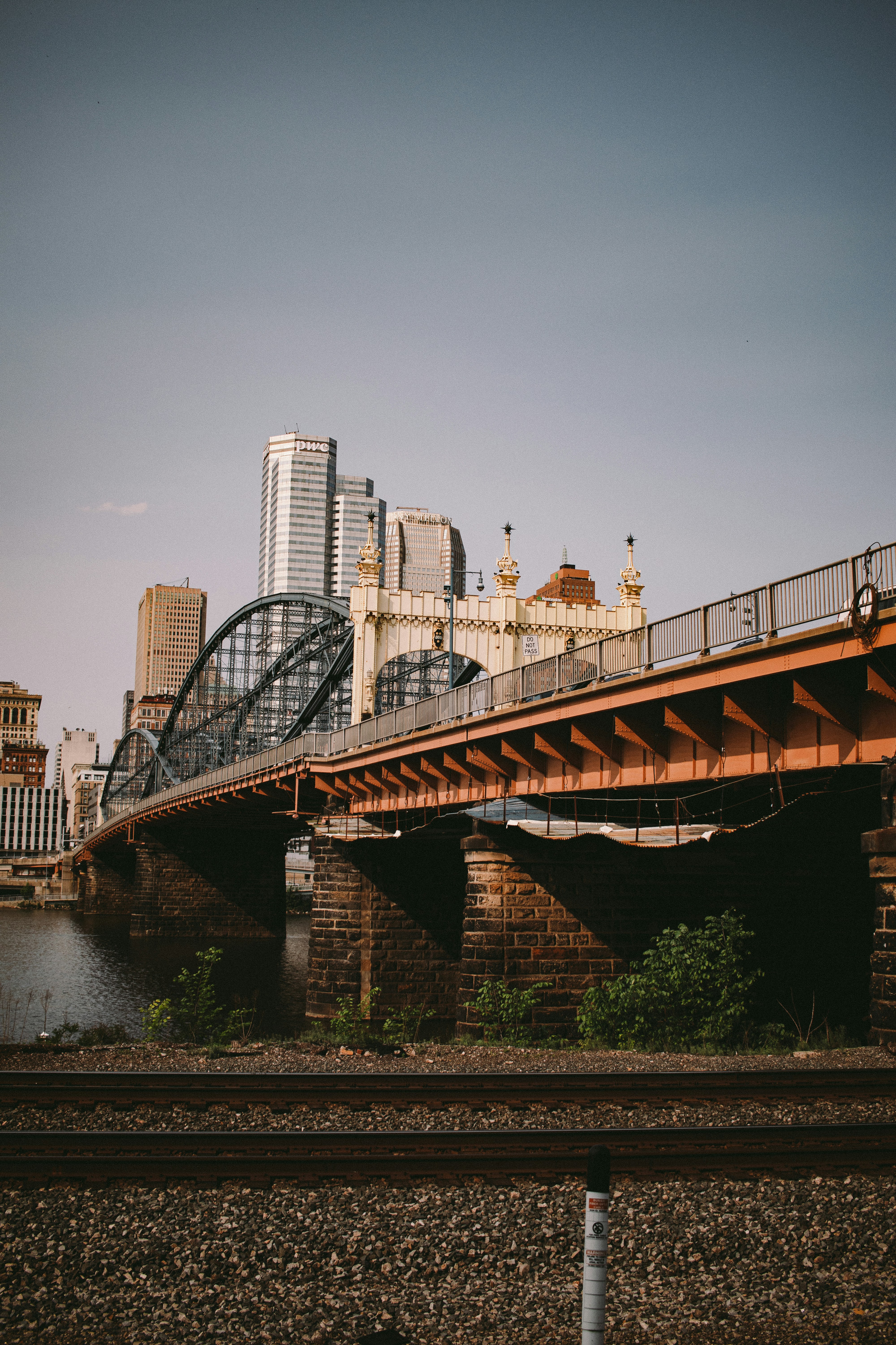 a bridge over a river with a city in the background