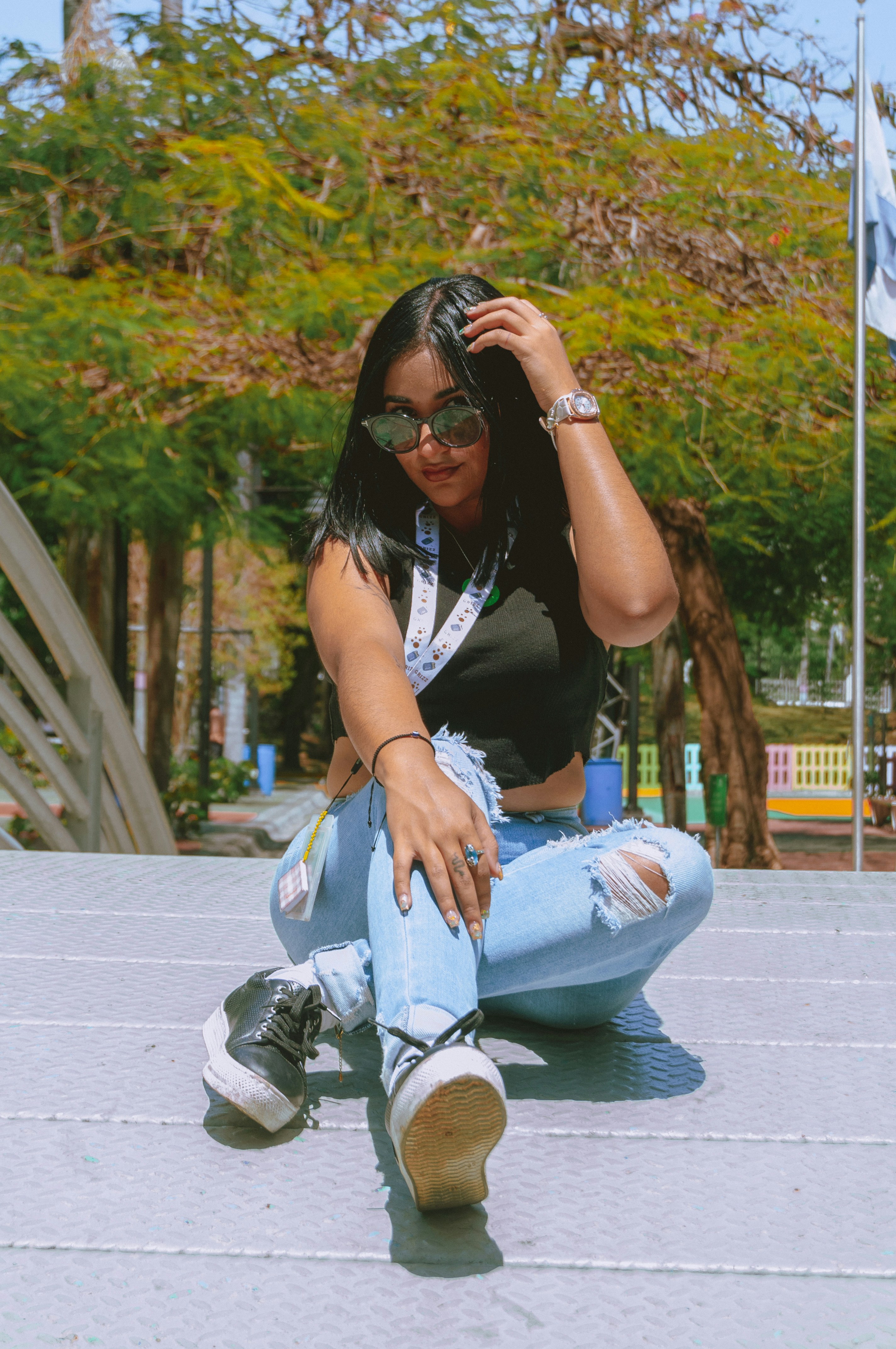 A woman sitting on the ground in ripped jeans photo – Free Parque ...