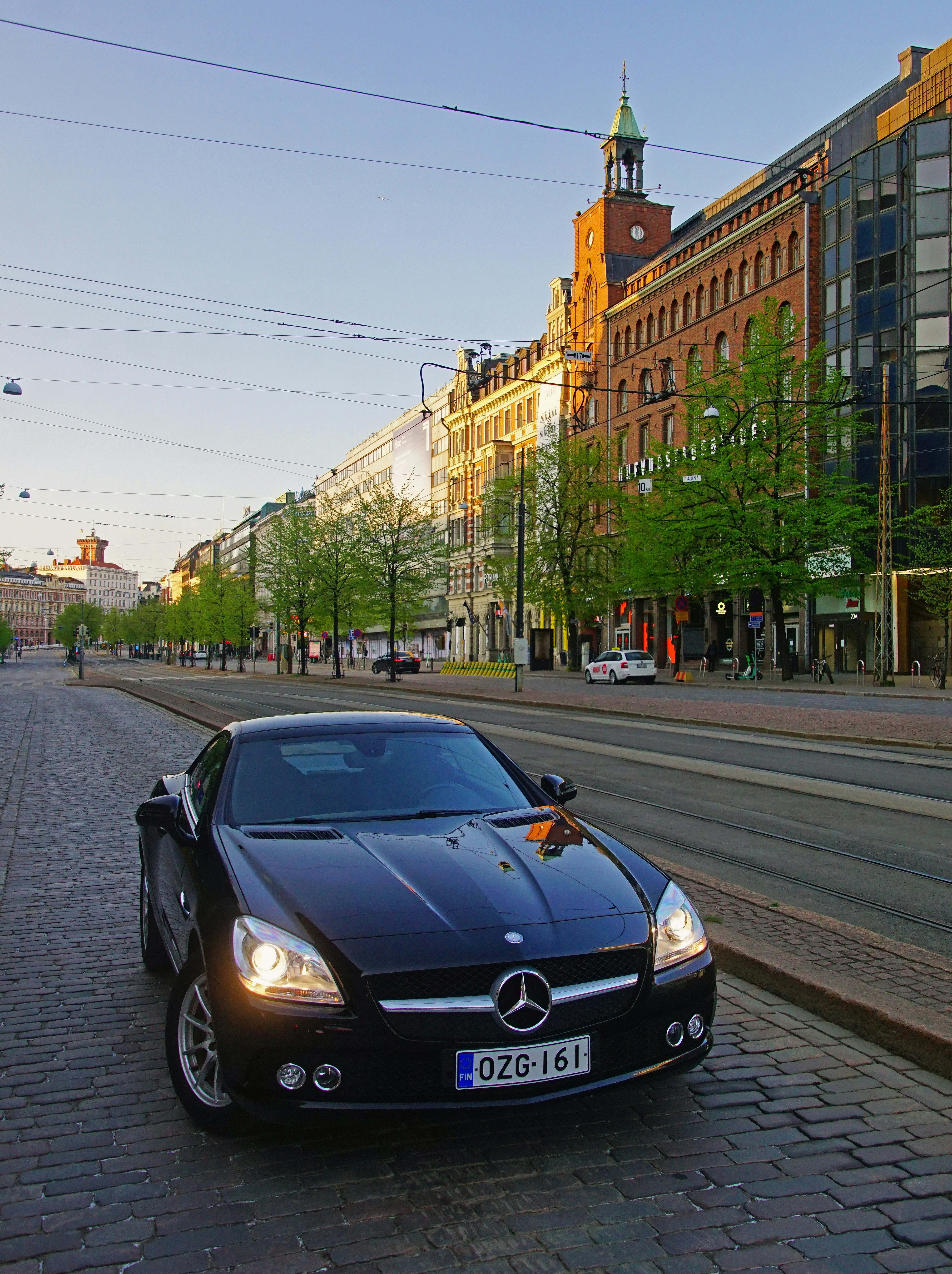 Chrome on Cobblestones: A Mercedes Anchors a Sunlit City Street