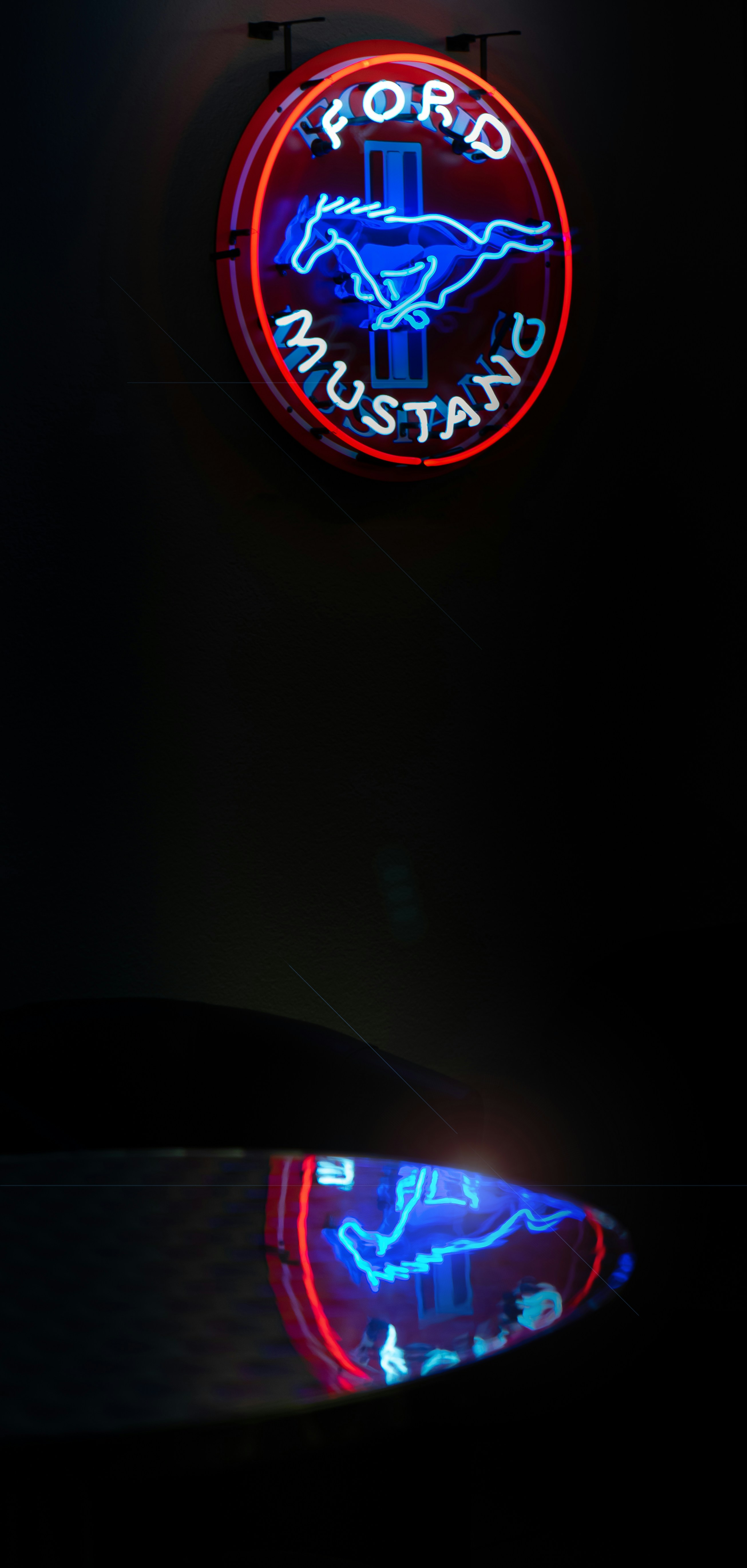 A ford mustang neon sign hanging from the side of a building photo ...