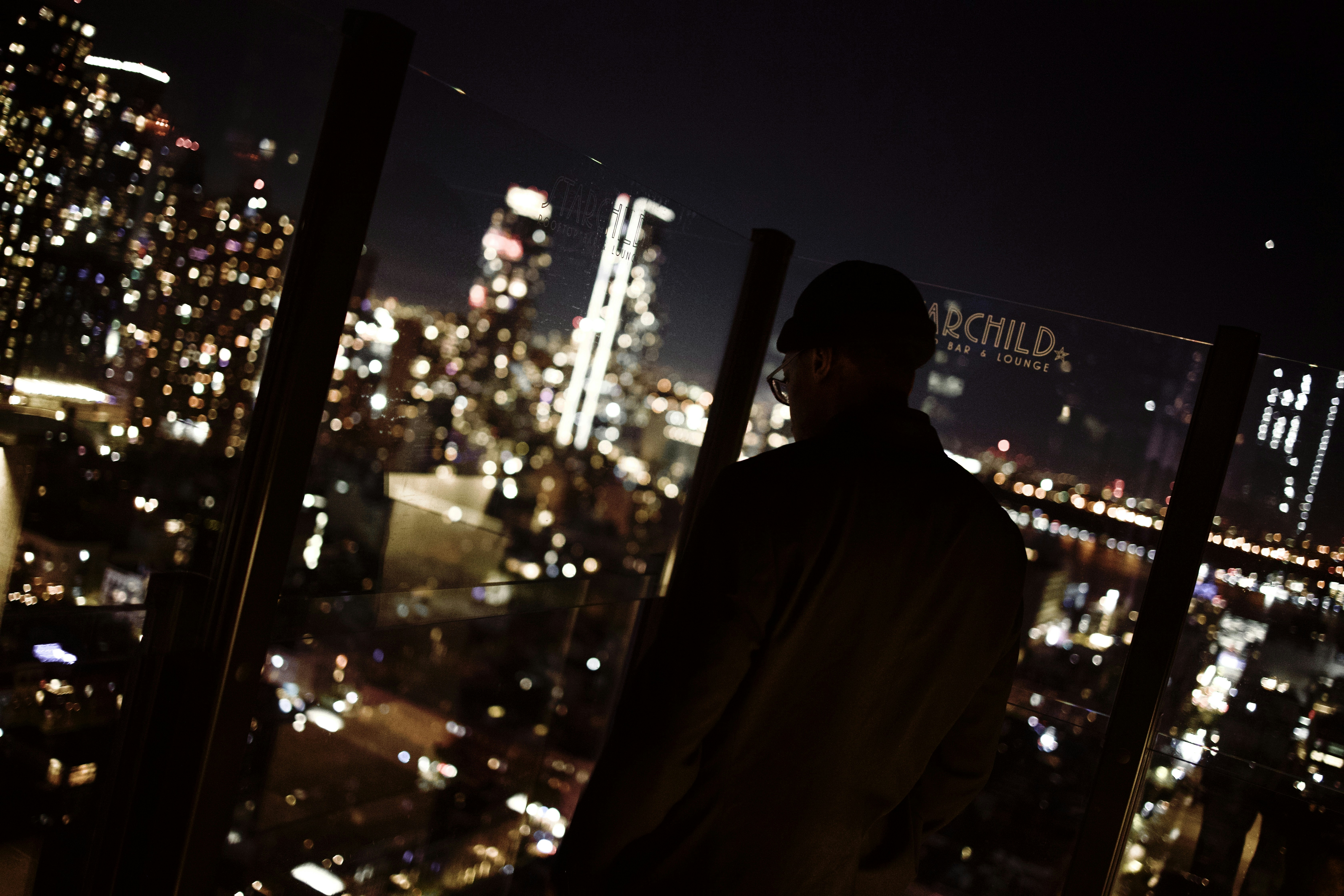 Silhouette Over Neon: A Night on the Rooftop