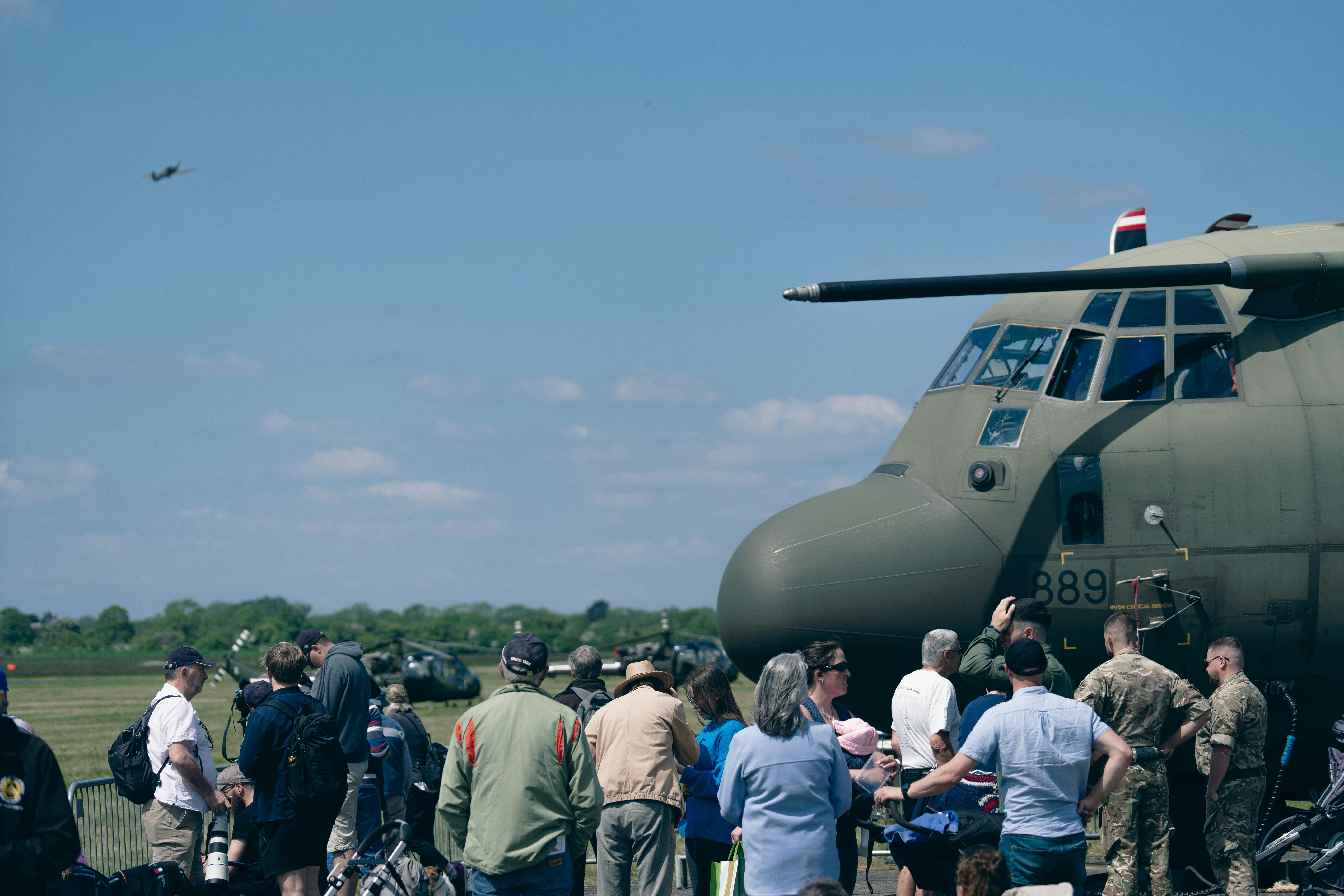 Crowd Gathers Around a Vintage Helicopter at a Public Air Show