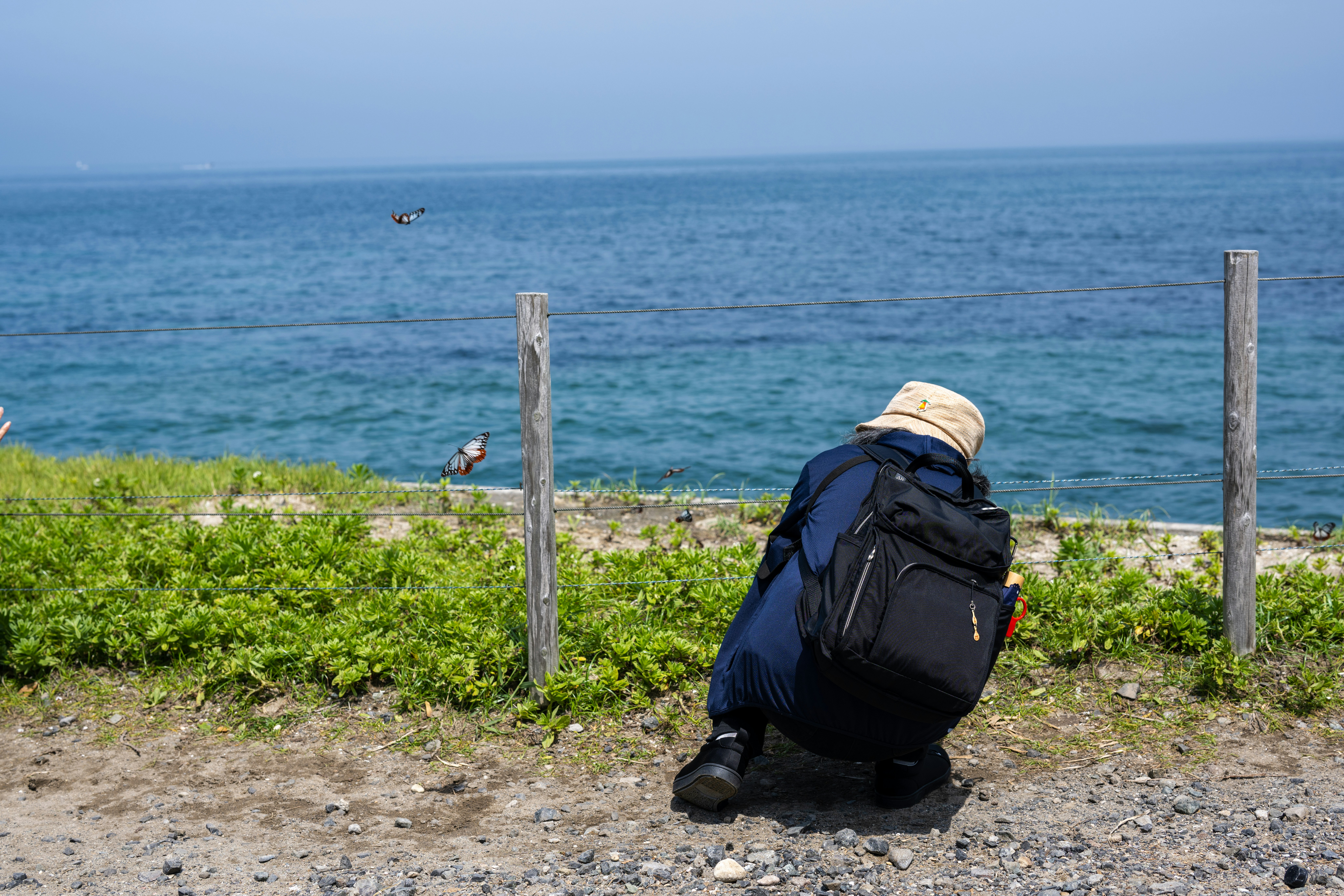 A person sitting on the ground with a backpack photo – Free Bag Image ...
