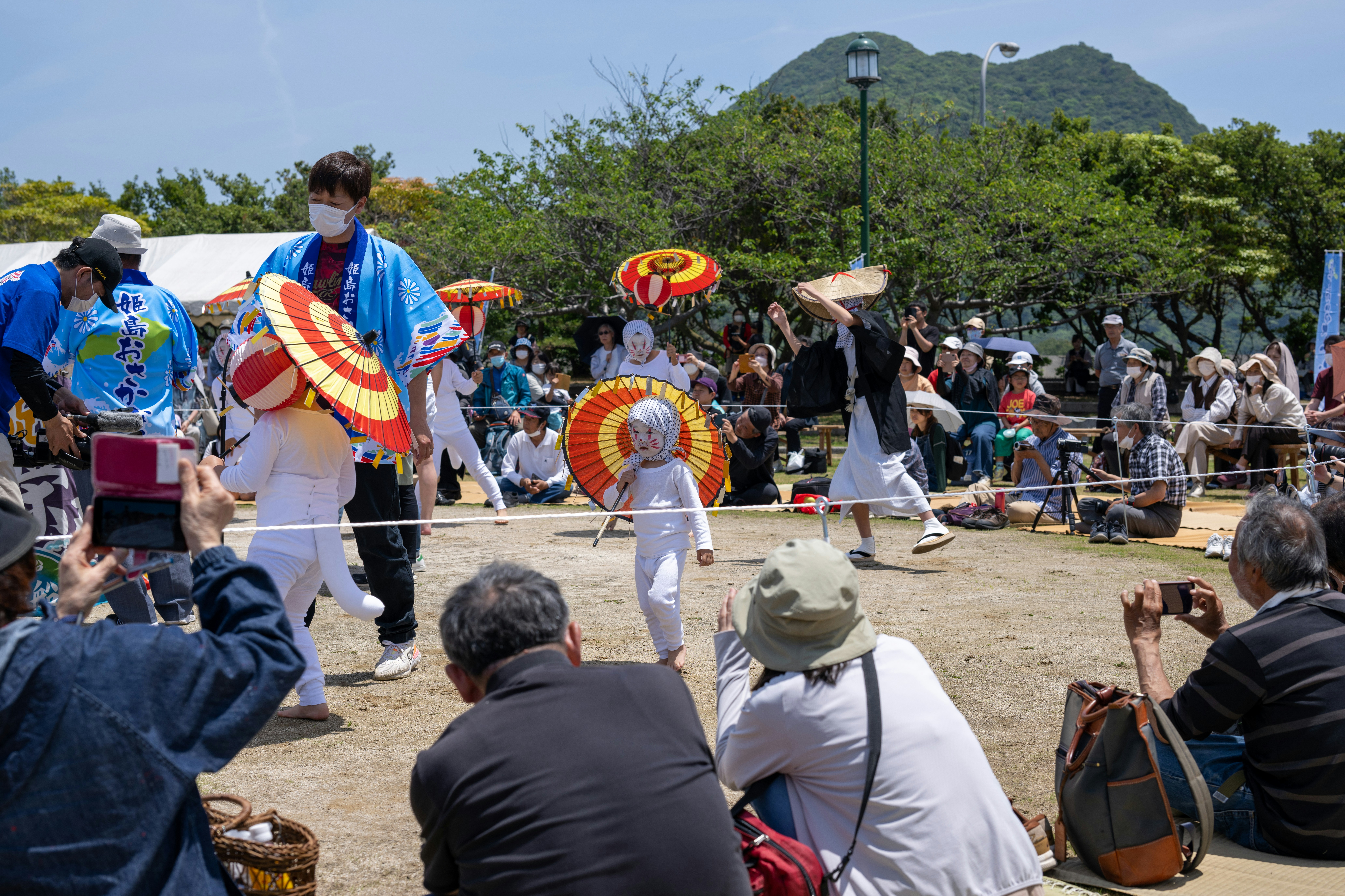 Crimson-Stripe Umbrella Dance at a Sunlit Festival