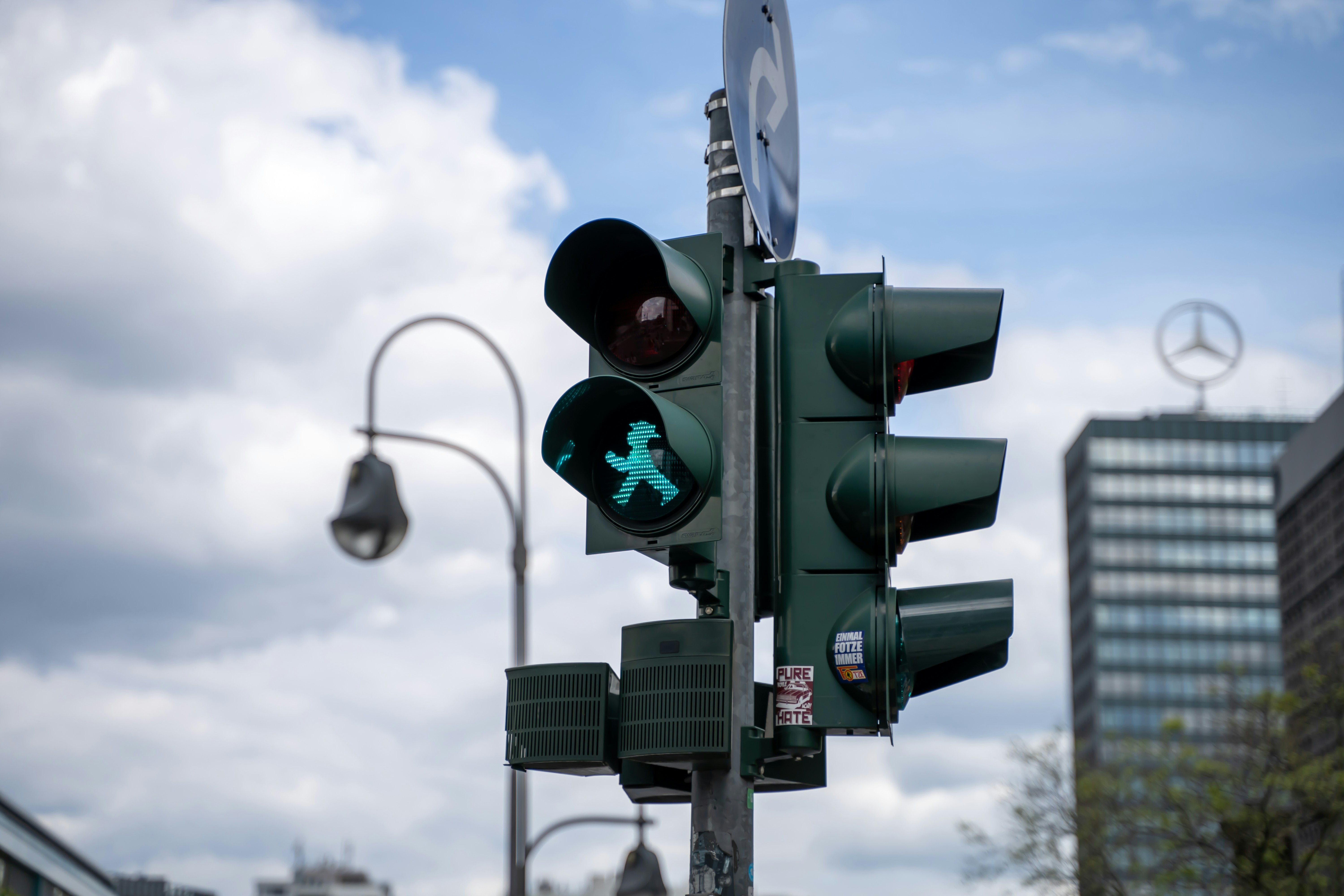 a traffic light with a pedestrian crossing sign on it