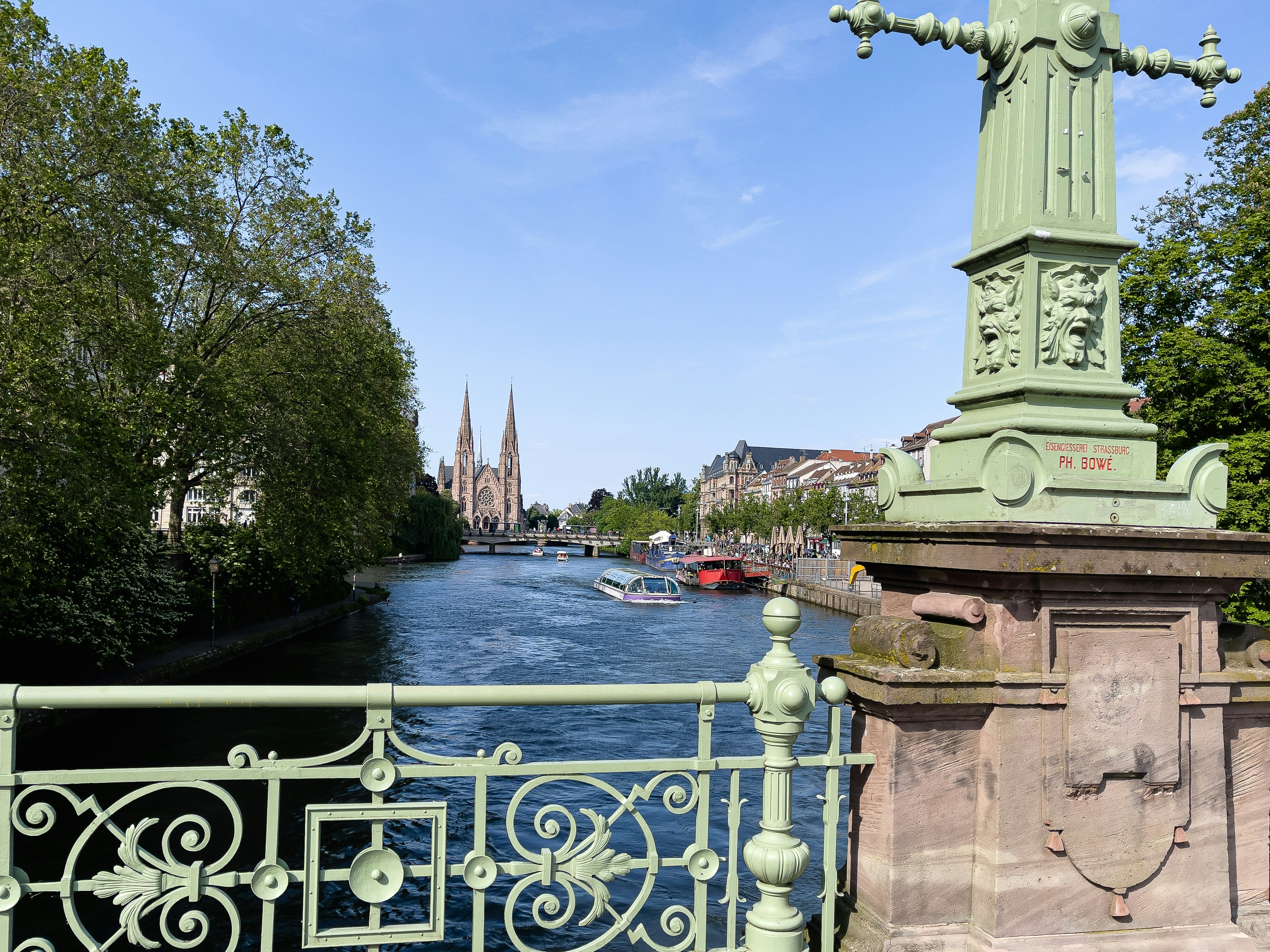Spires on the Horizon: Green Railings Framing a Quiet River