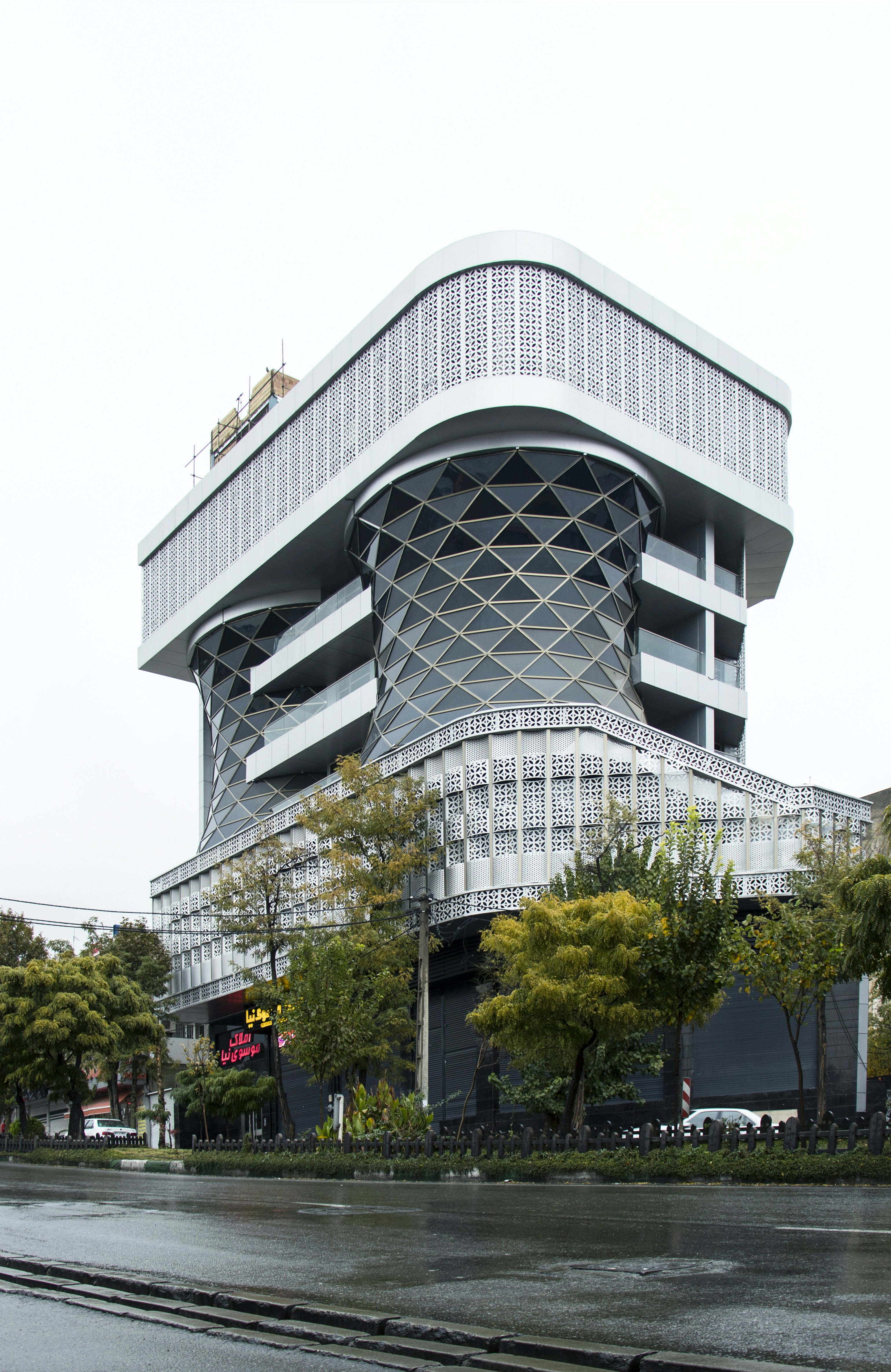 A tall building with a curved roof on a rainy day photo – Free Karaj ...