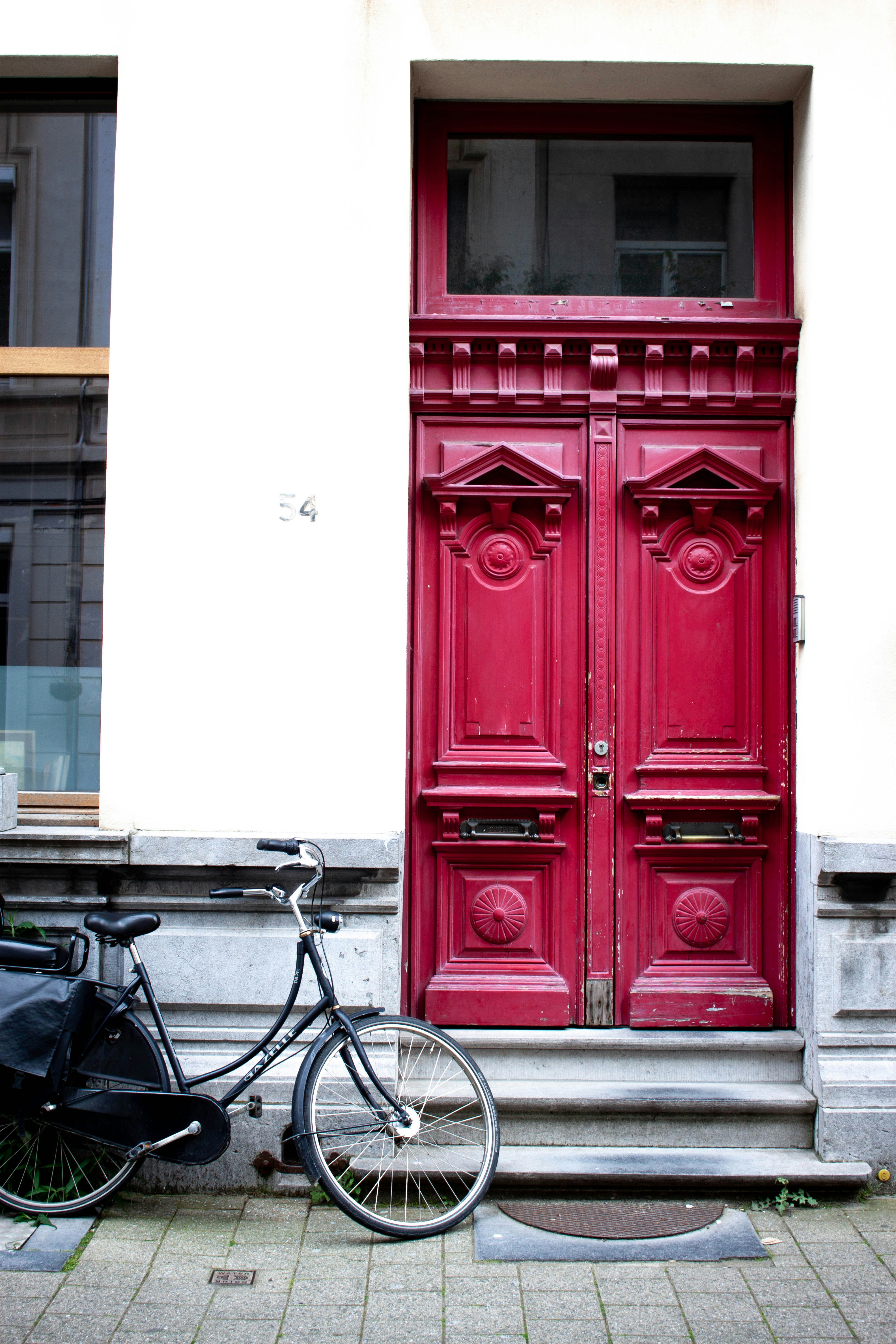 Crimson Threshold: A Red Doorway Framed by a Quiet City Bicycle