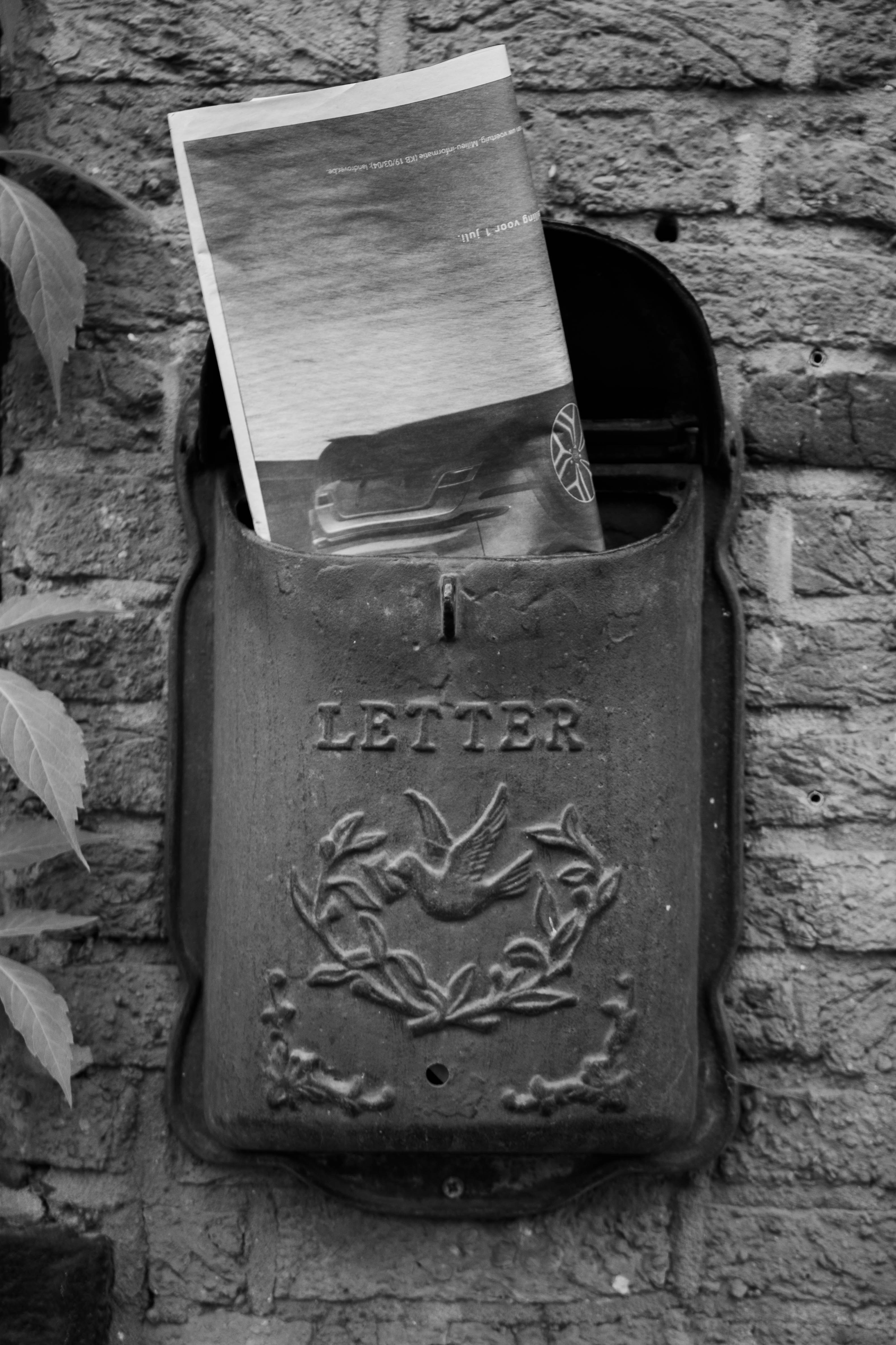 Weathered Mailbox Reverie: A Magazine Peeks from the Slot