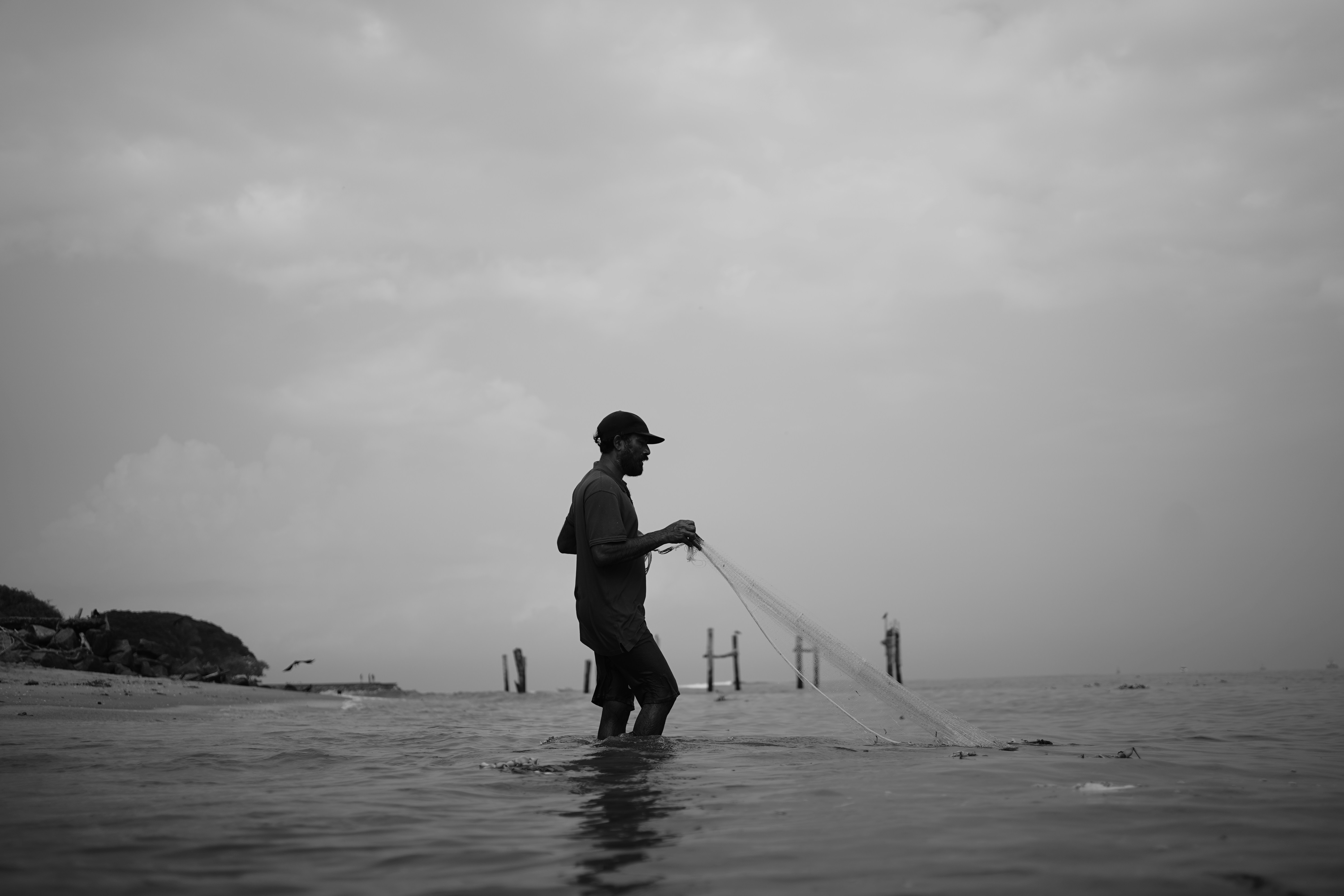 A man standing in the water holding a net photo – Free Fishing Image on ...