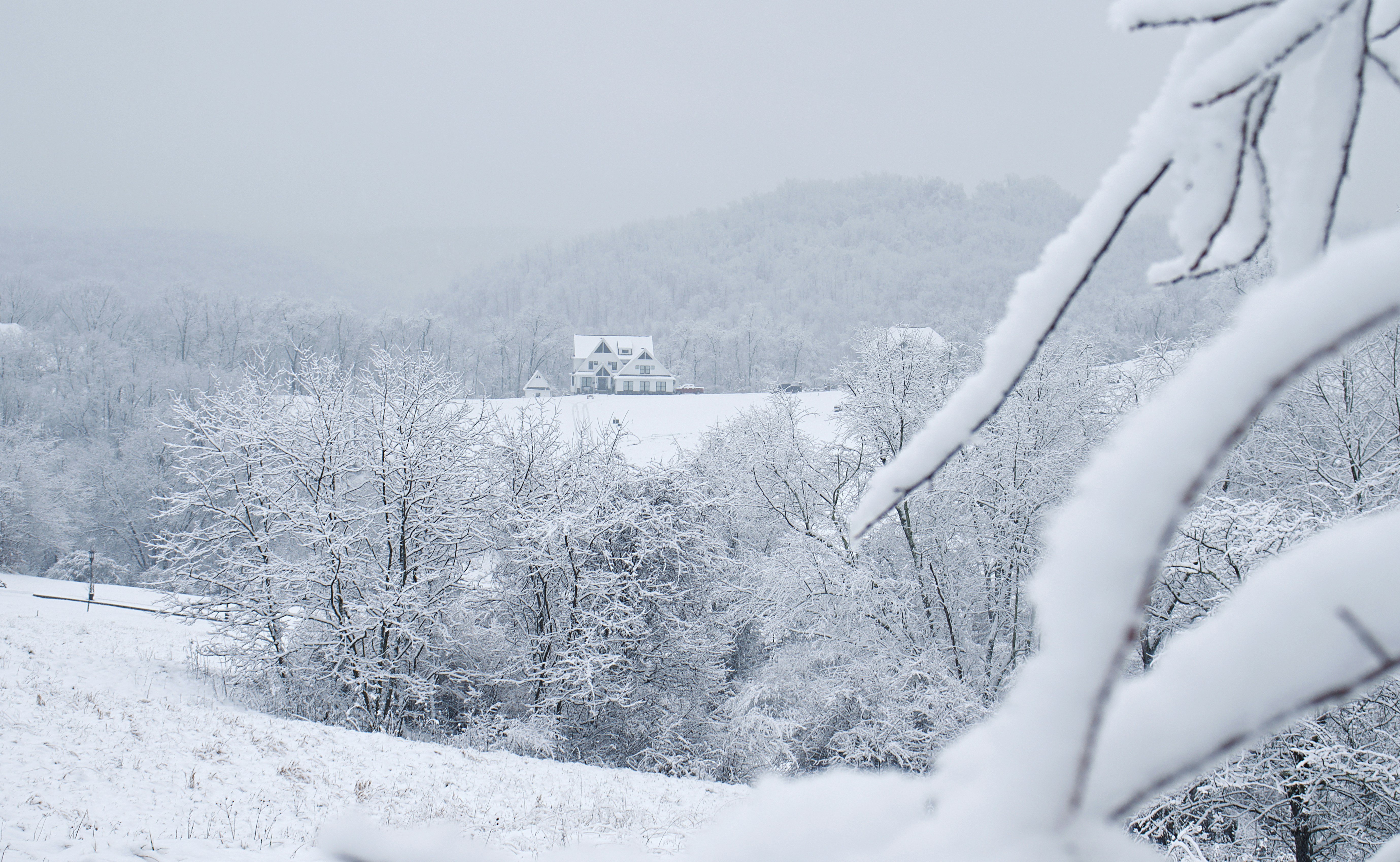 A snowy landscape with a house in the distance photo – Free Snow Image ...