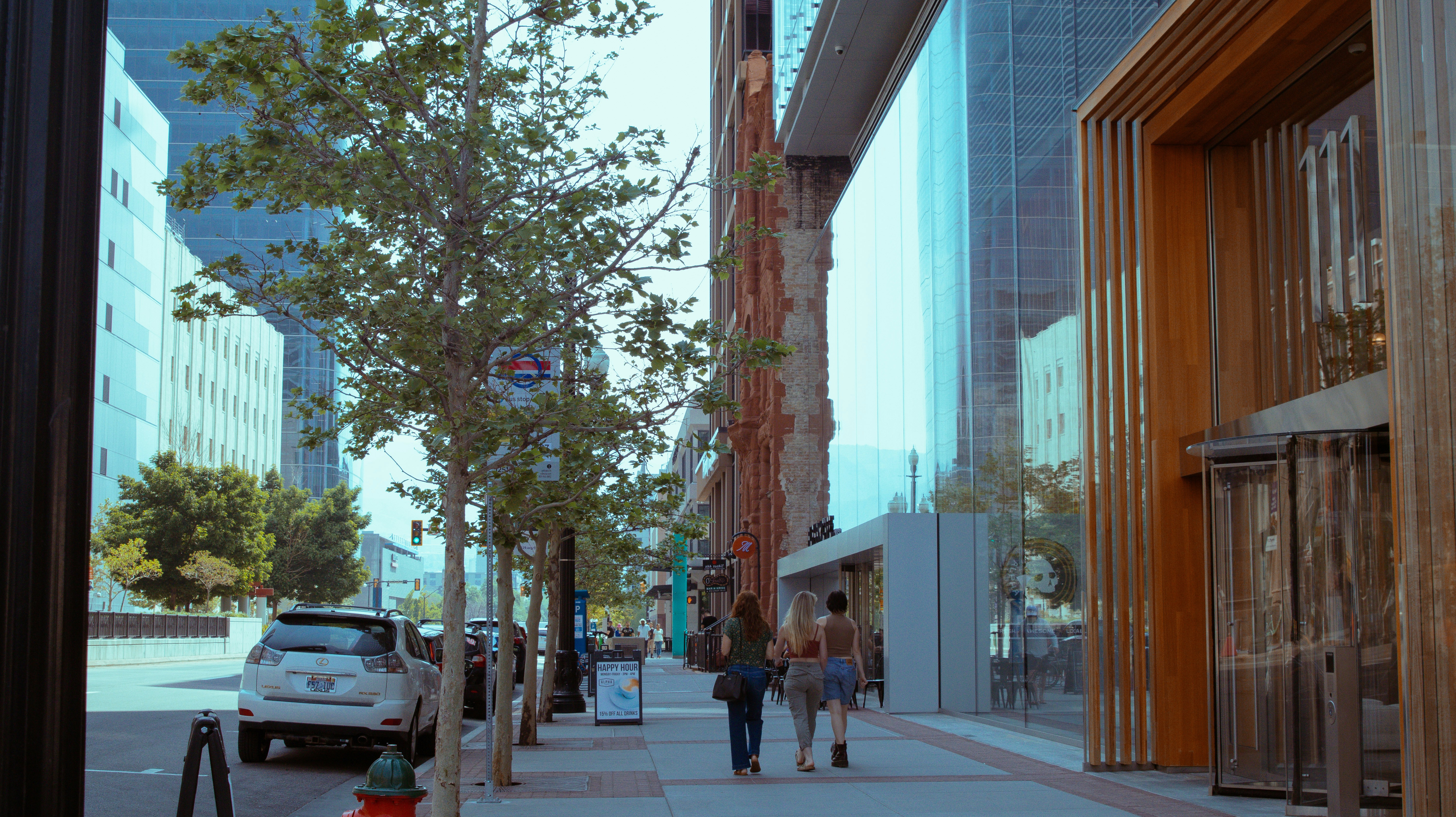 Blue Glass Boulevard: Pedestrians Amid a Quiet Street of Reflections