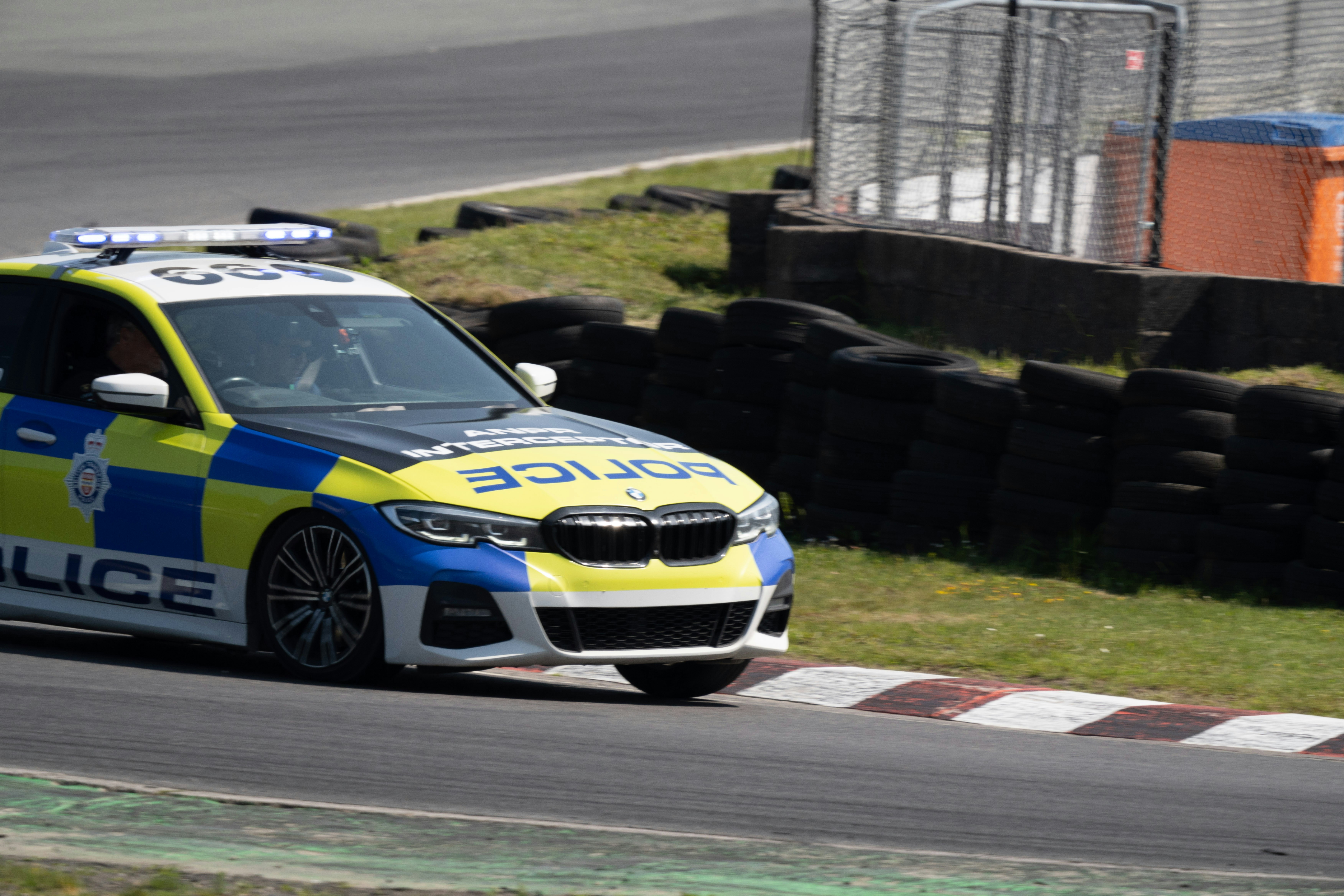 A police car driving down a race track photo – Free Uk Image on Unsplash