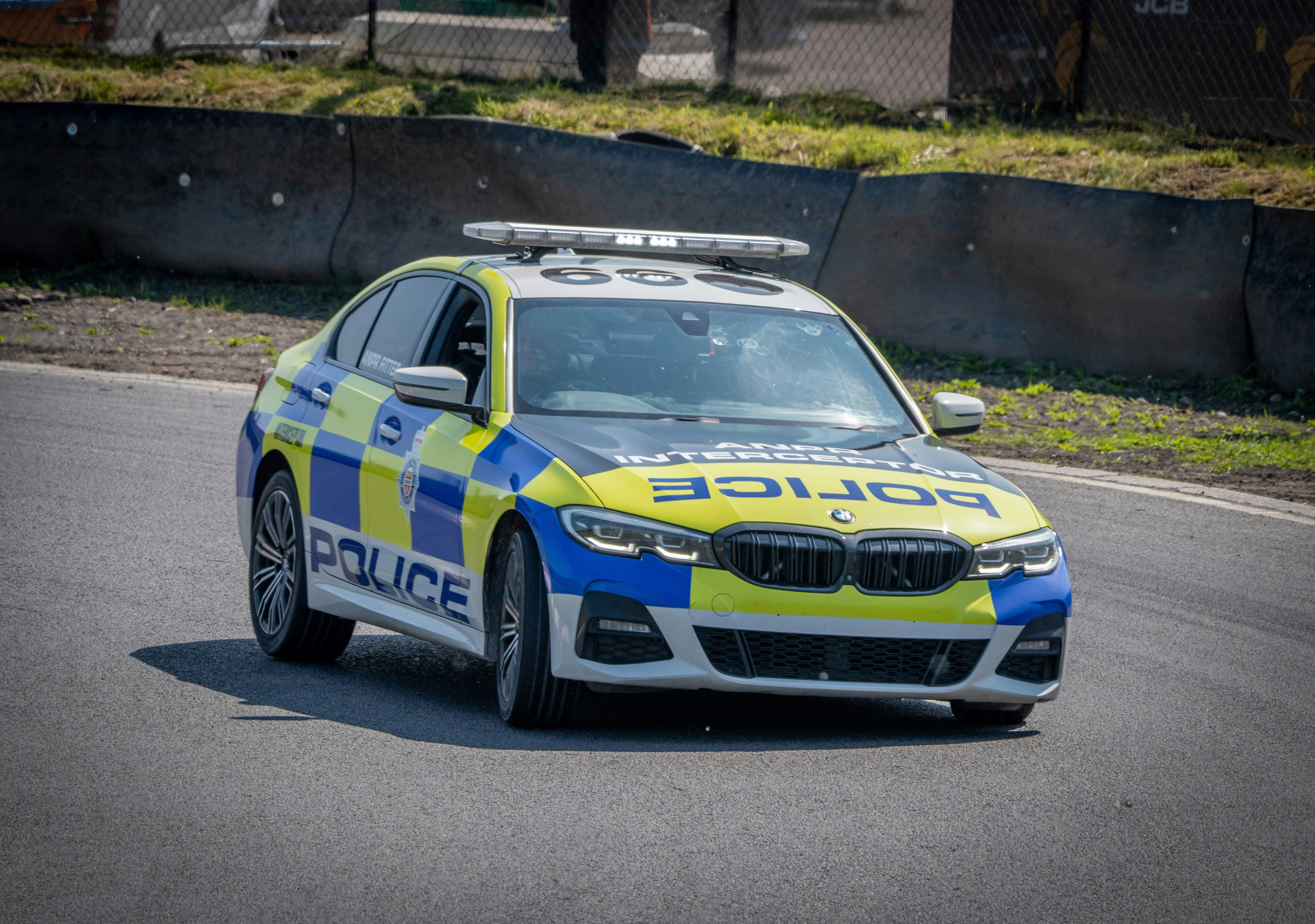 A police car driving down a race track photo – Free Uk Image on Unsplash