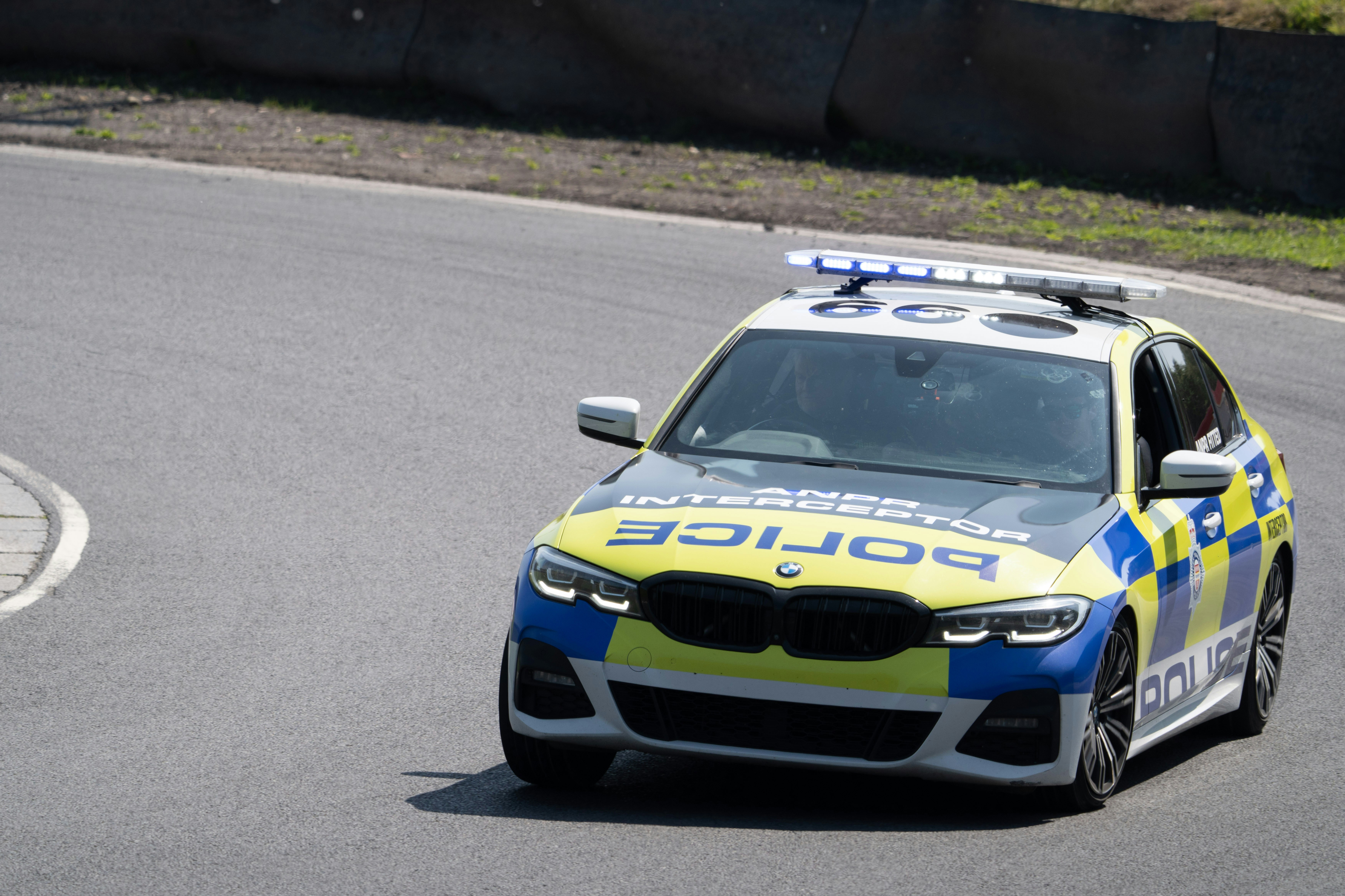 A police car driving down a race track photo – Free Three sisters race ...
