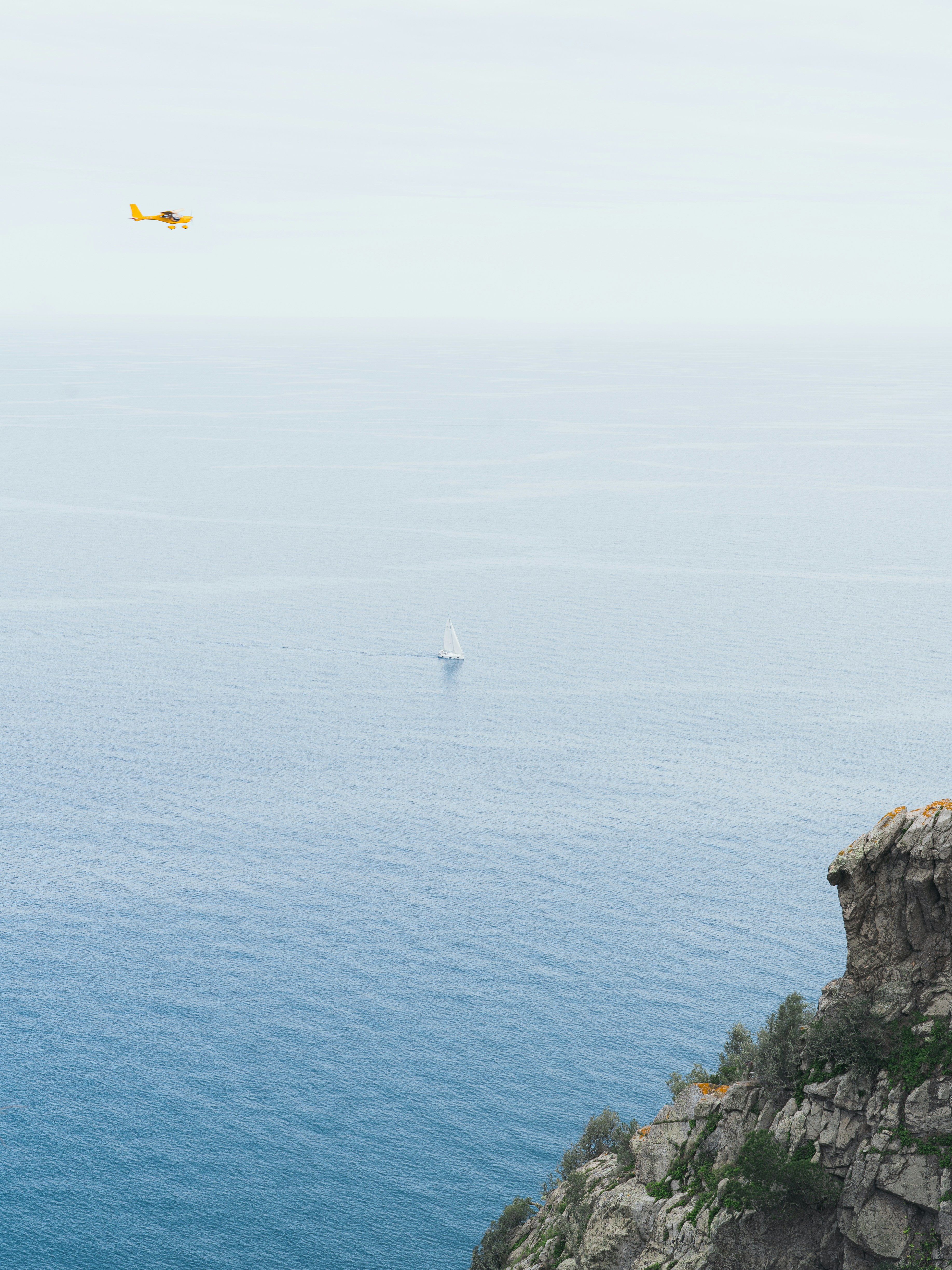 A small plane flying over a large body of water photo – Free Cliff ...