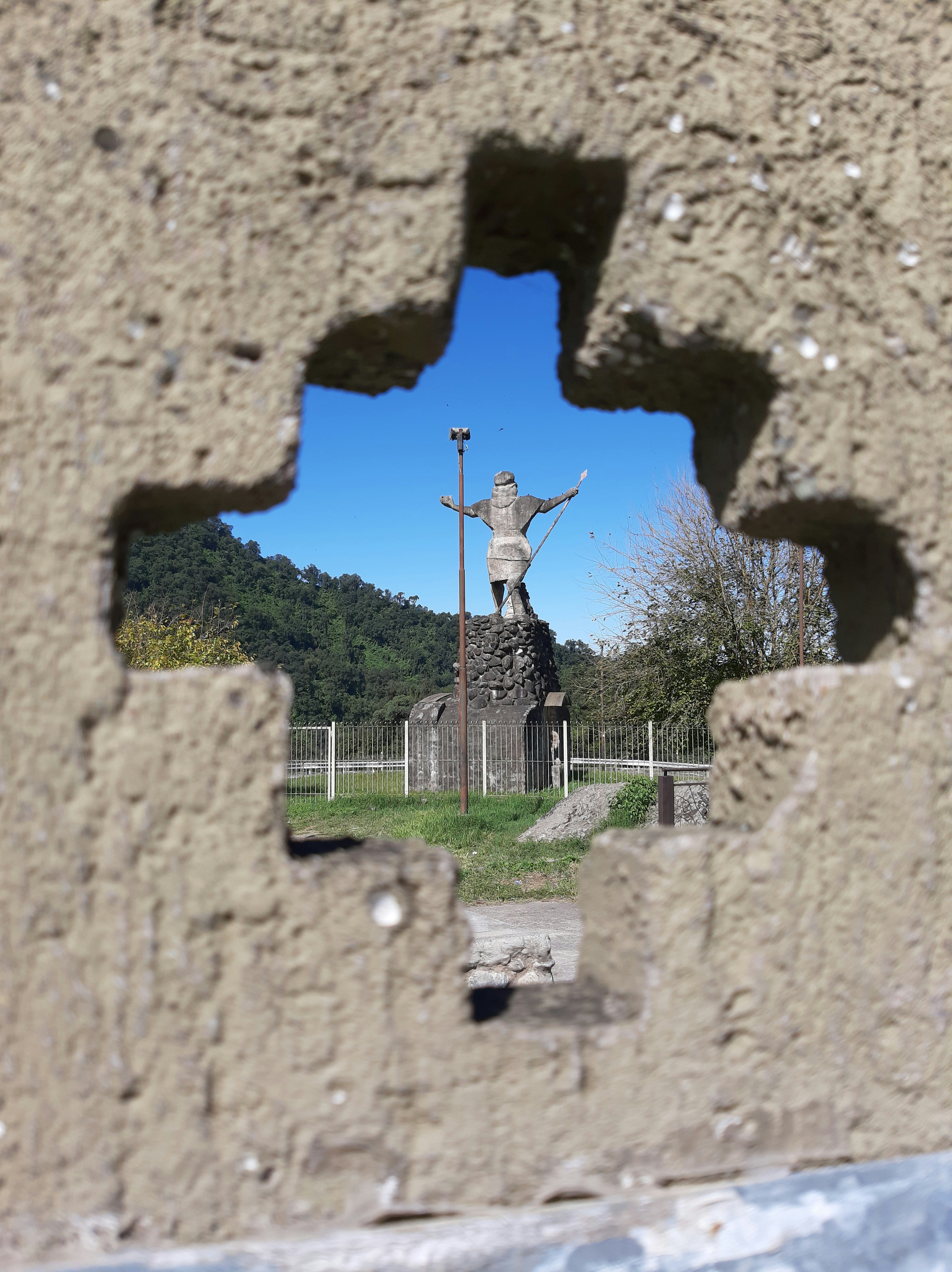 Fragmented View: Statue Framed by a Weathered Aperture