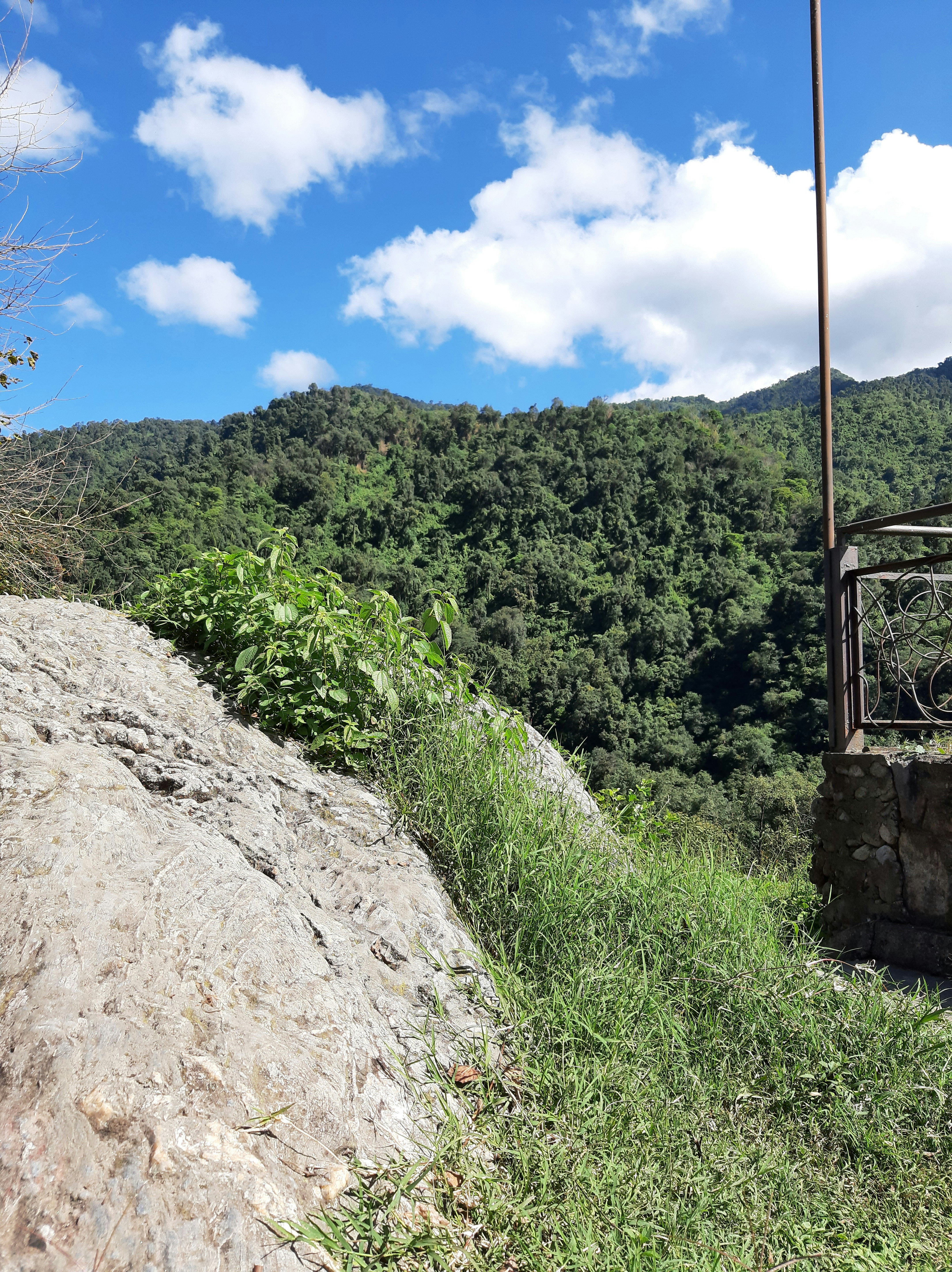 Rocky Verge Overlook: Greens, Iron Rail, and a Clear Sky