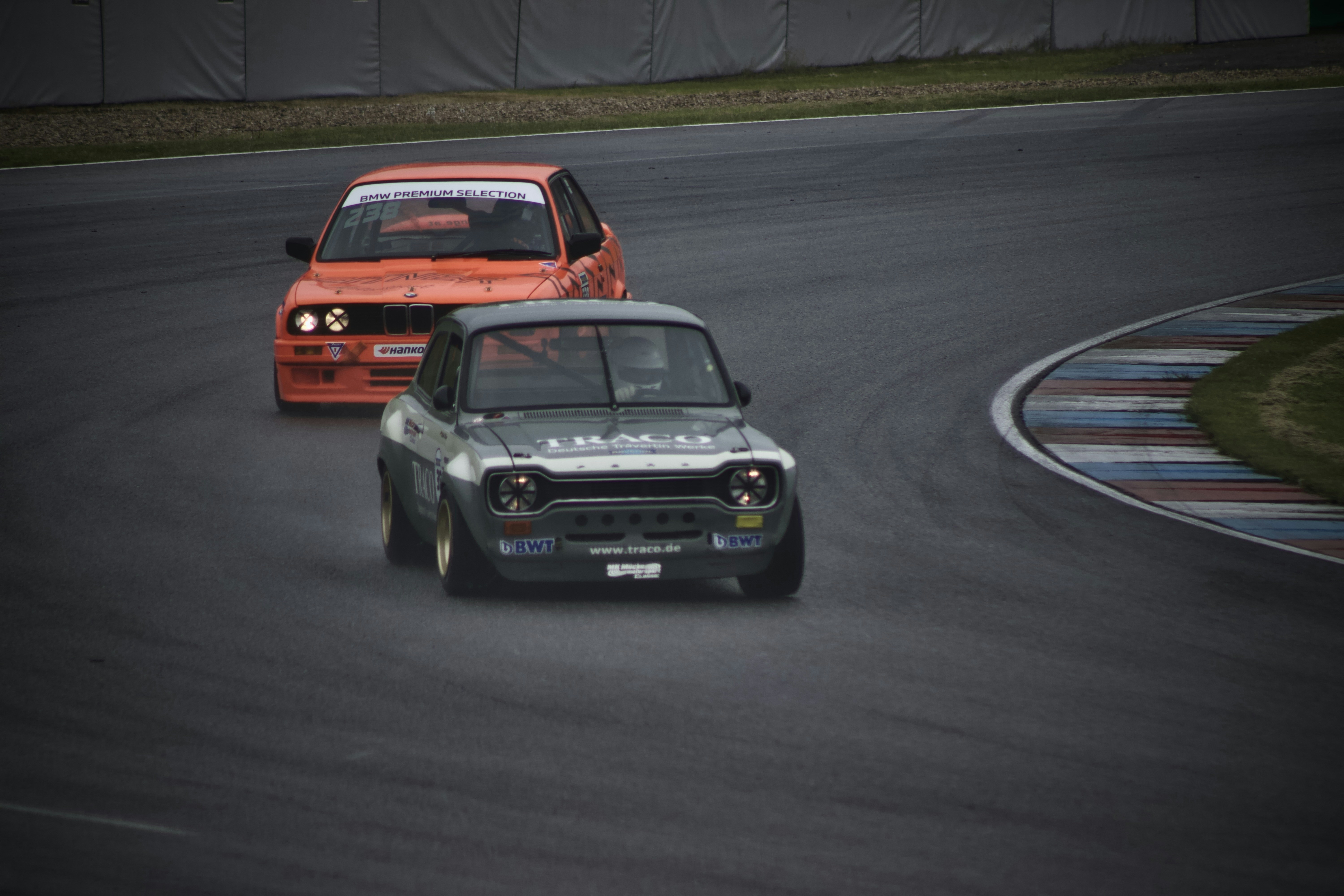 Dos coches conduciendo en una pista de carreras uno al lado del otro ...
