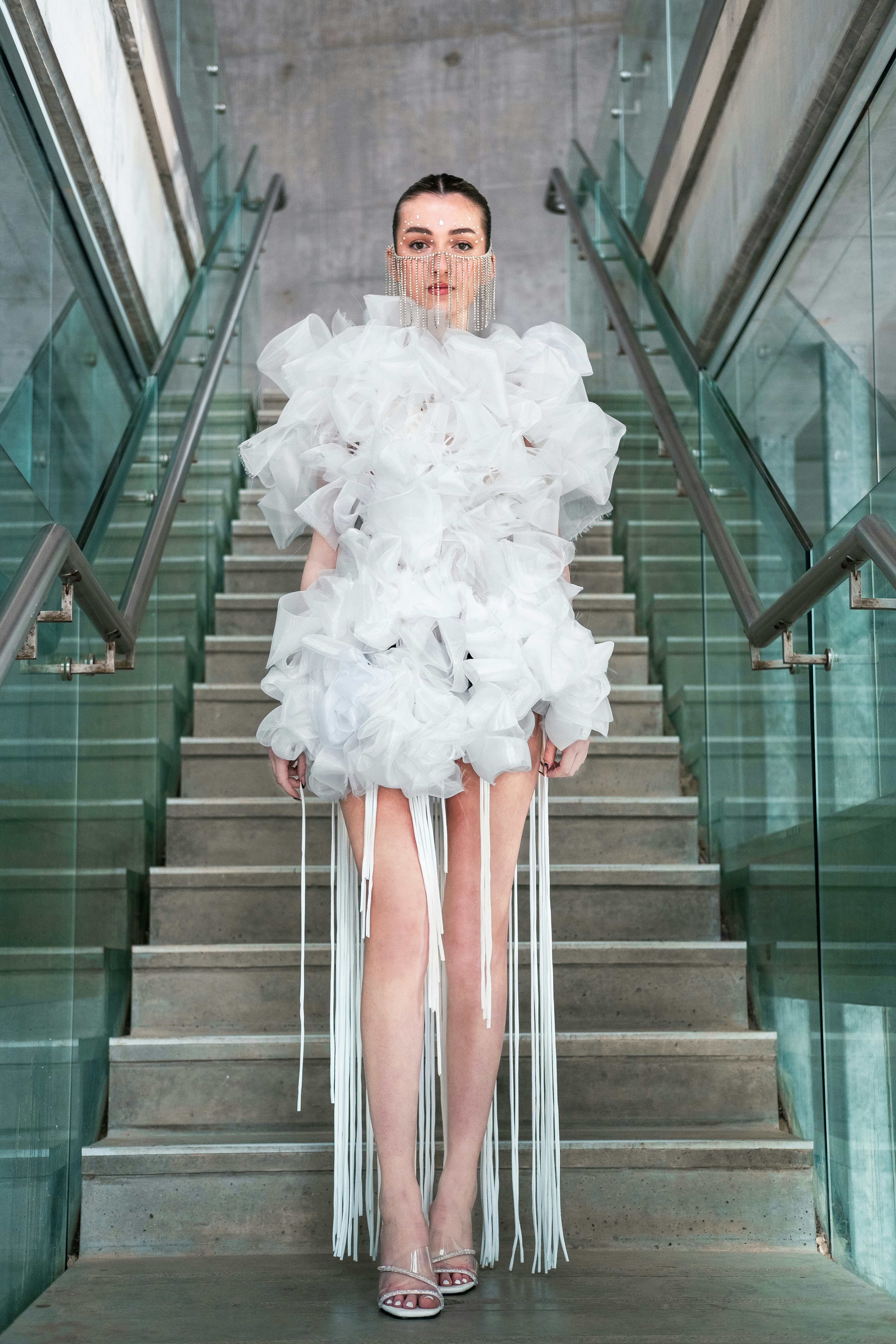 Glass Staircase Couture: A White Ruffle Moment on a Modern Ascension