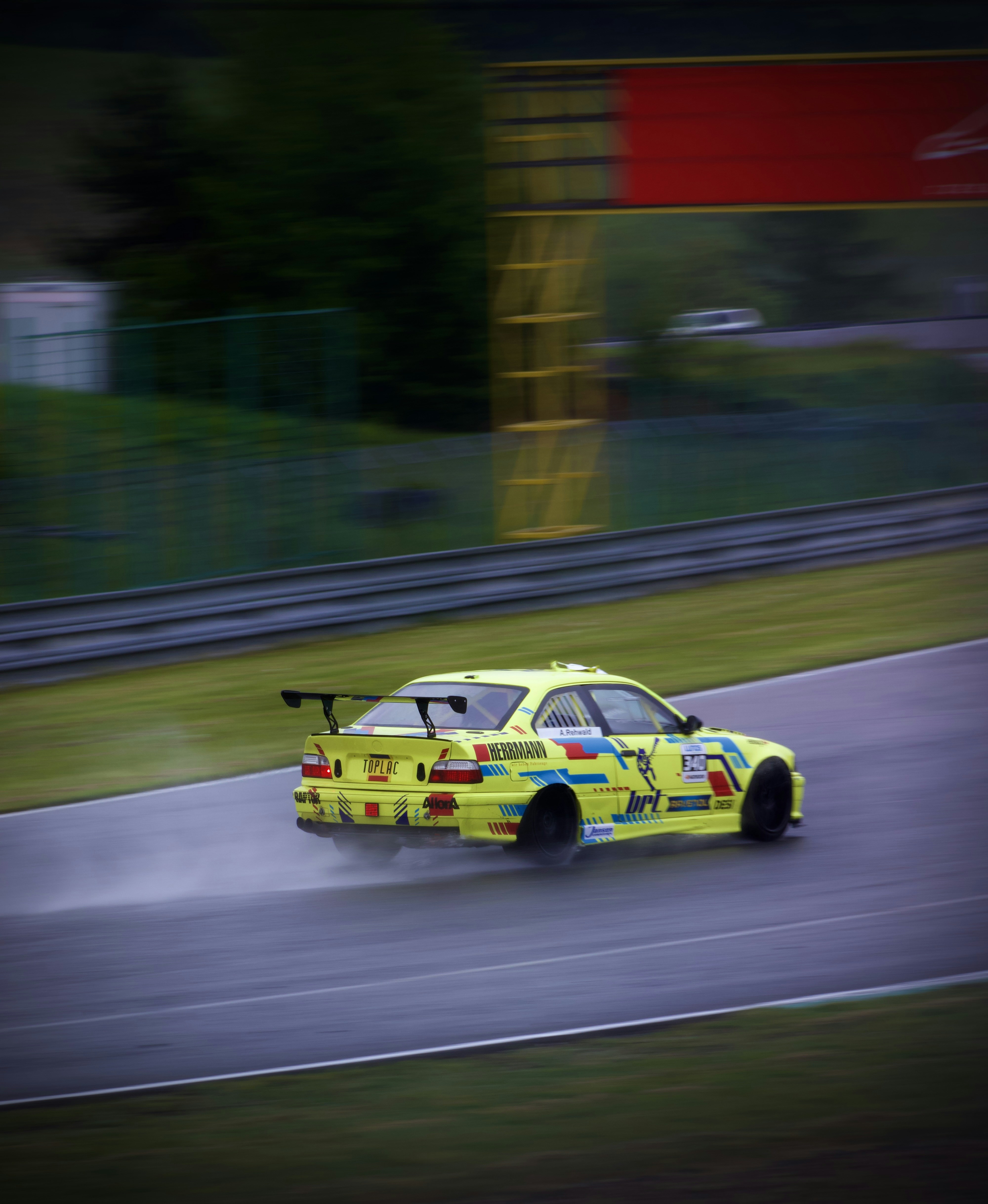 A yellow car driving down a race track photo – Free Road Image on Unsplash