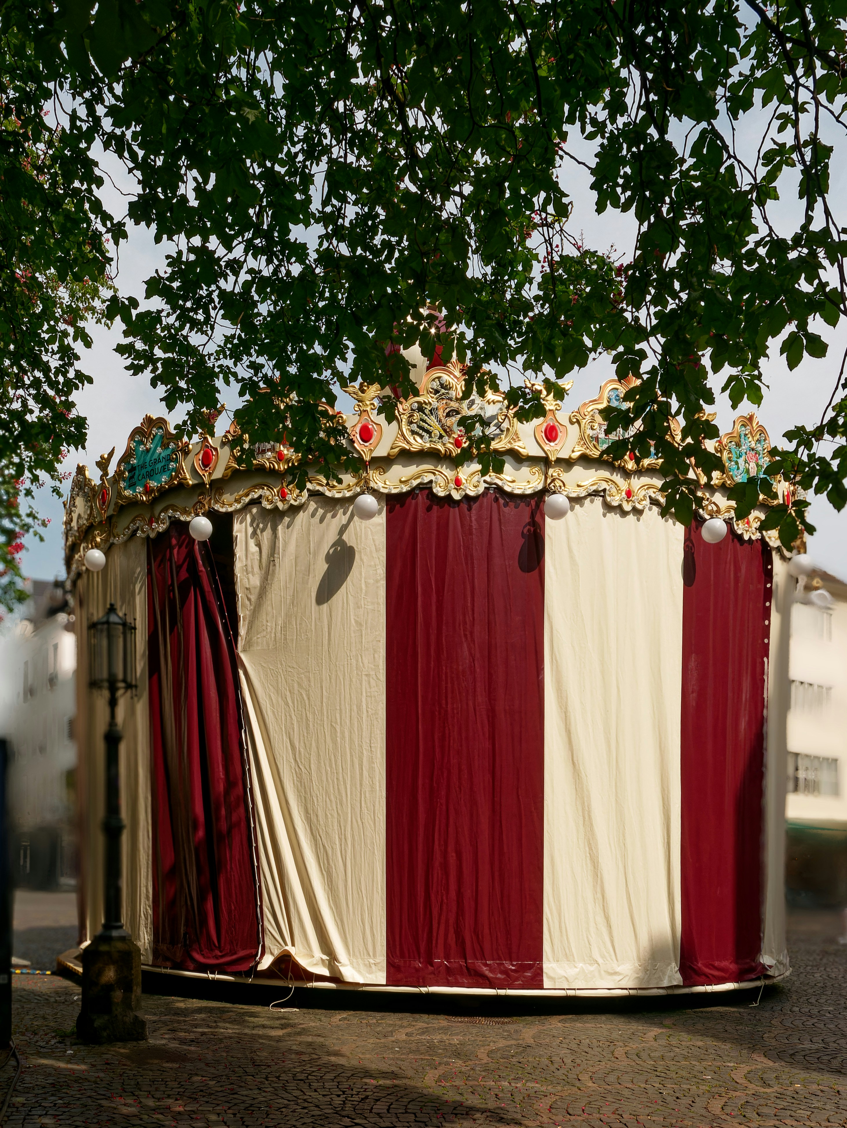 A red, white and blue circus tent sitting under a tree photo – Free ...