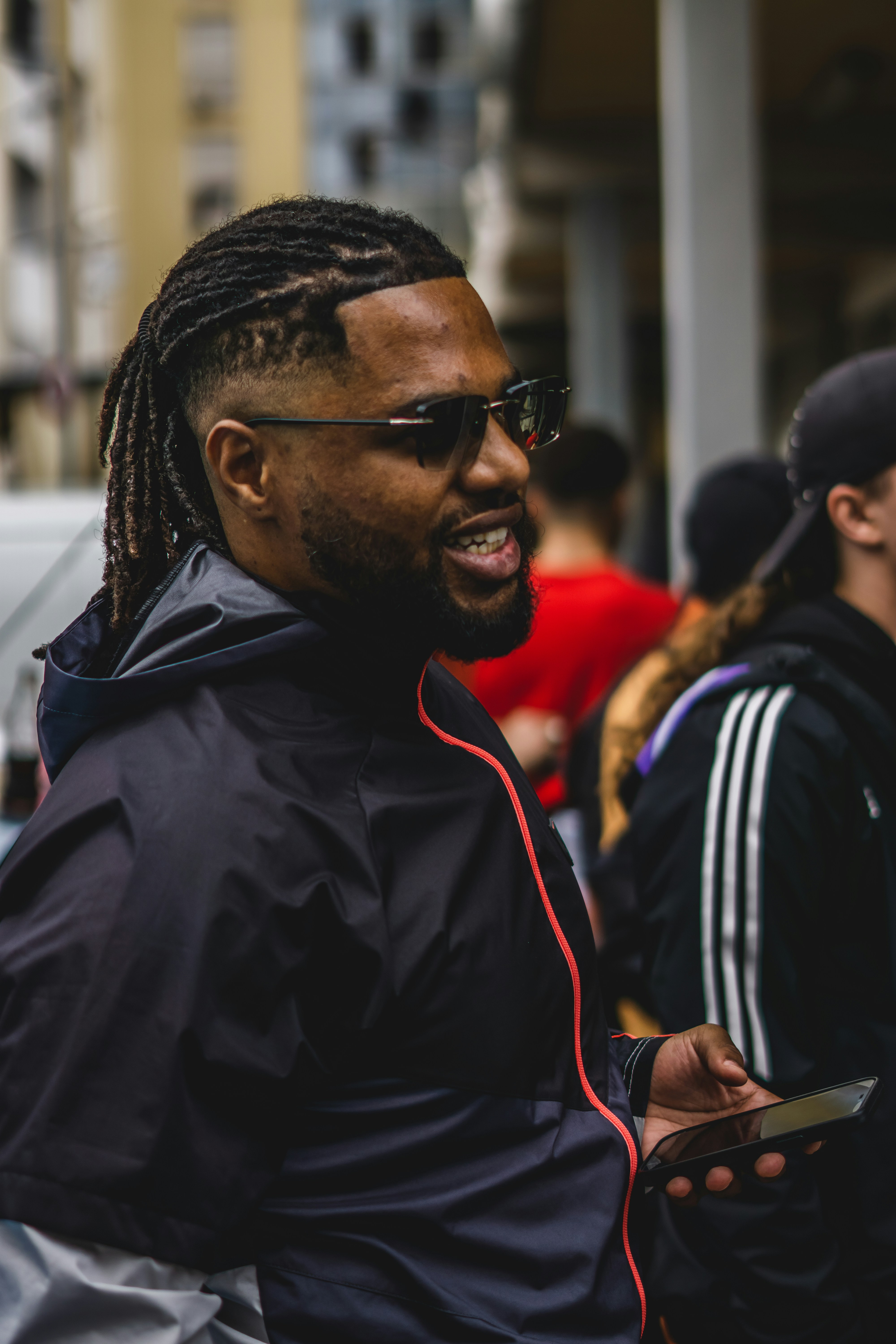 Portrait of a Conversational Moment: A Street Scene with a Bearded Man in Sunglasses