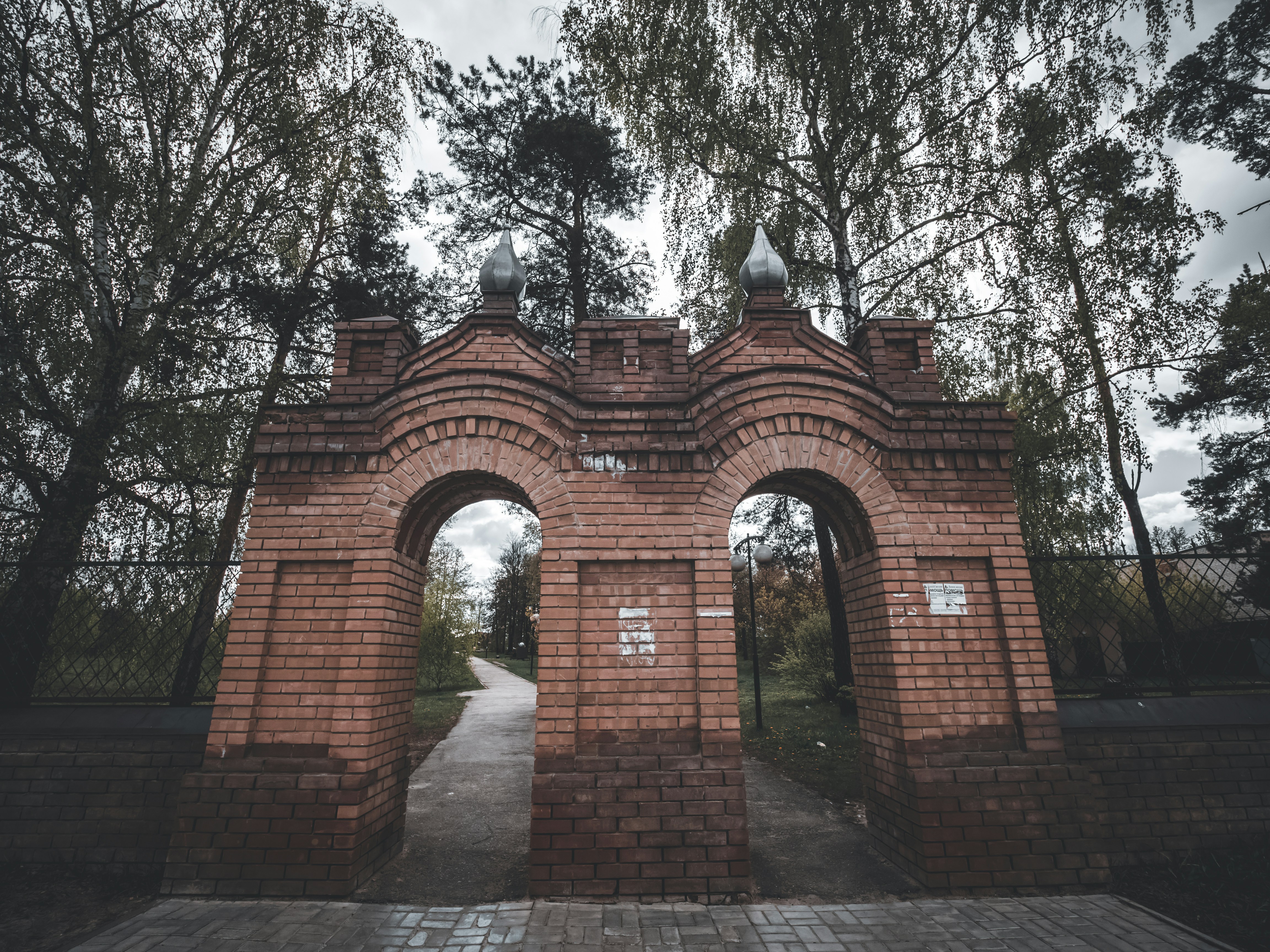 Brick Archway Gateway Framed by Tall Trees
