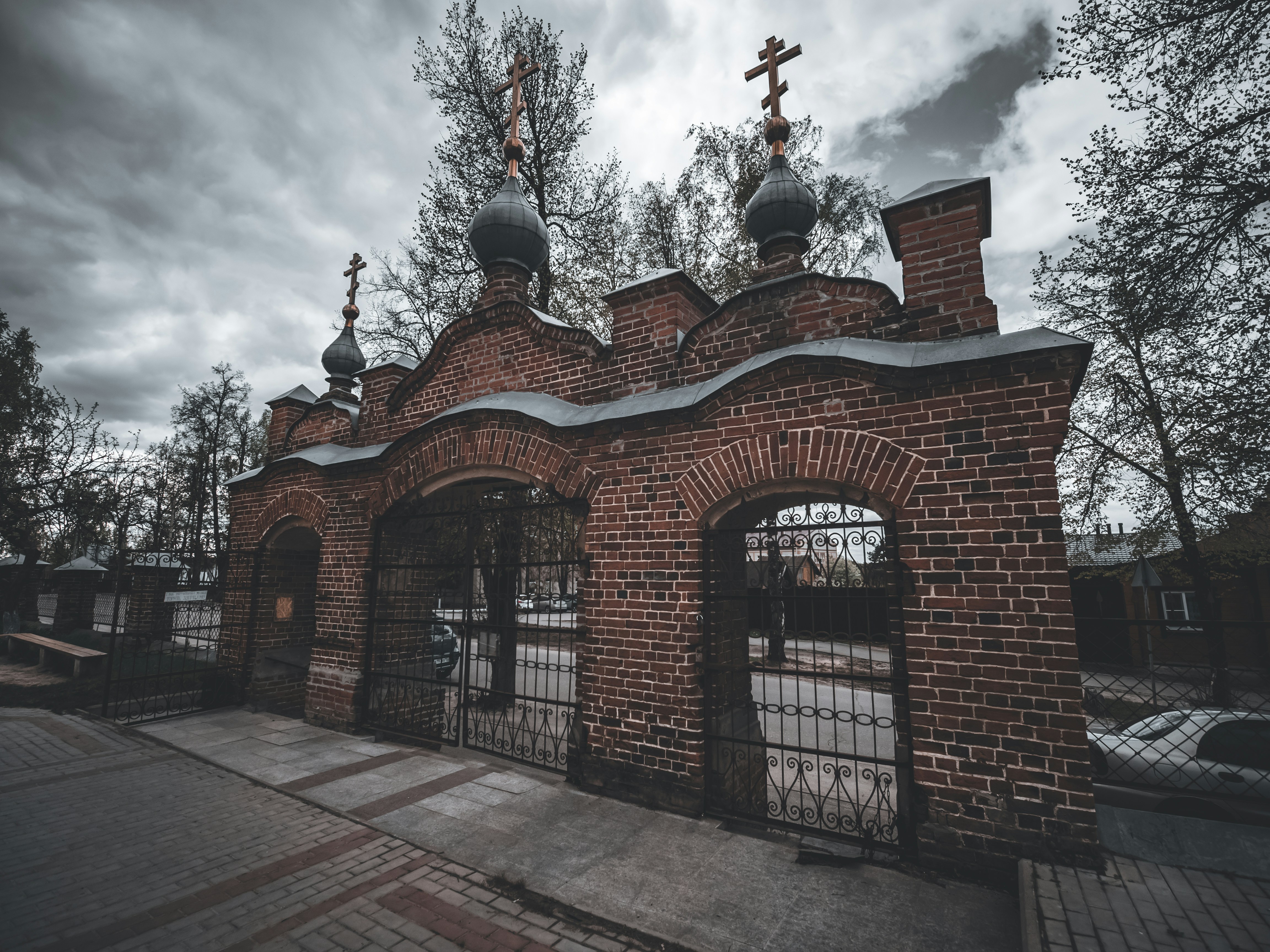 Brick Gate with Onion Domes Framing a Quiet Monastic Courtyard