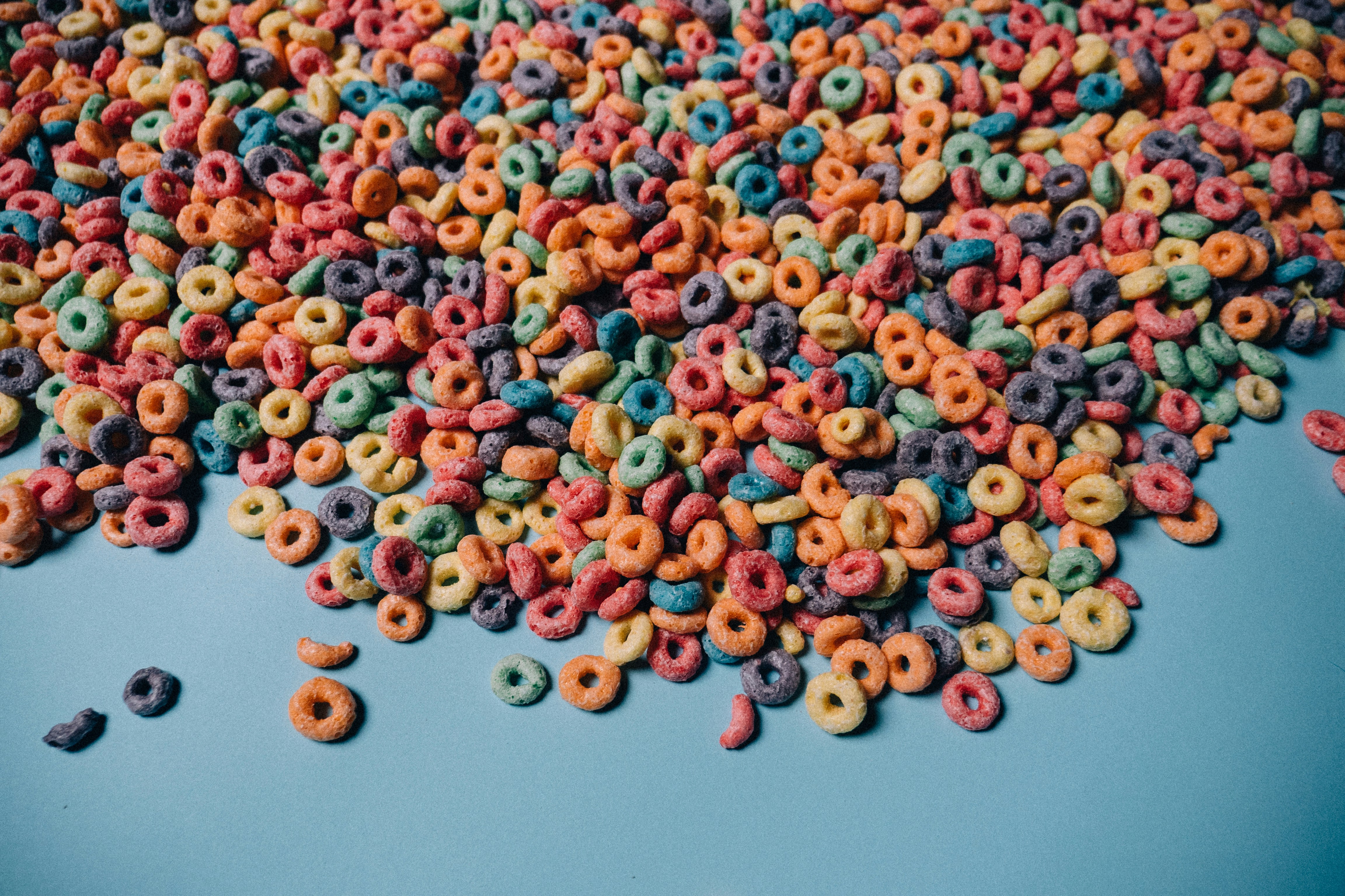 Rainbow Ring Cereal Spill on a Turquoise Surface