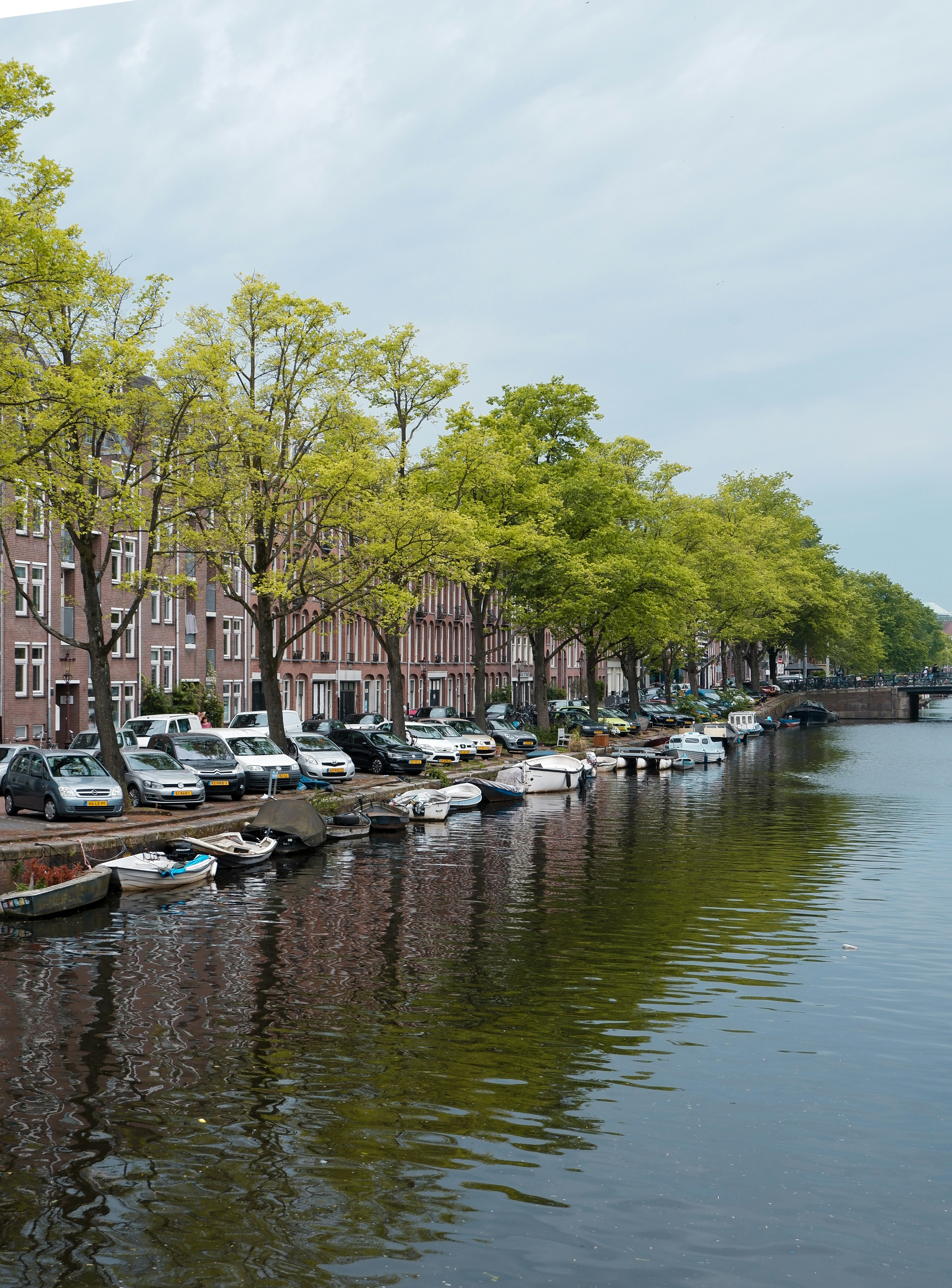 a row of parked boats sitting next to a river