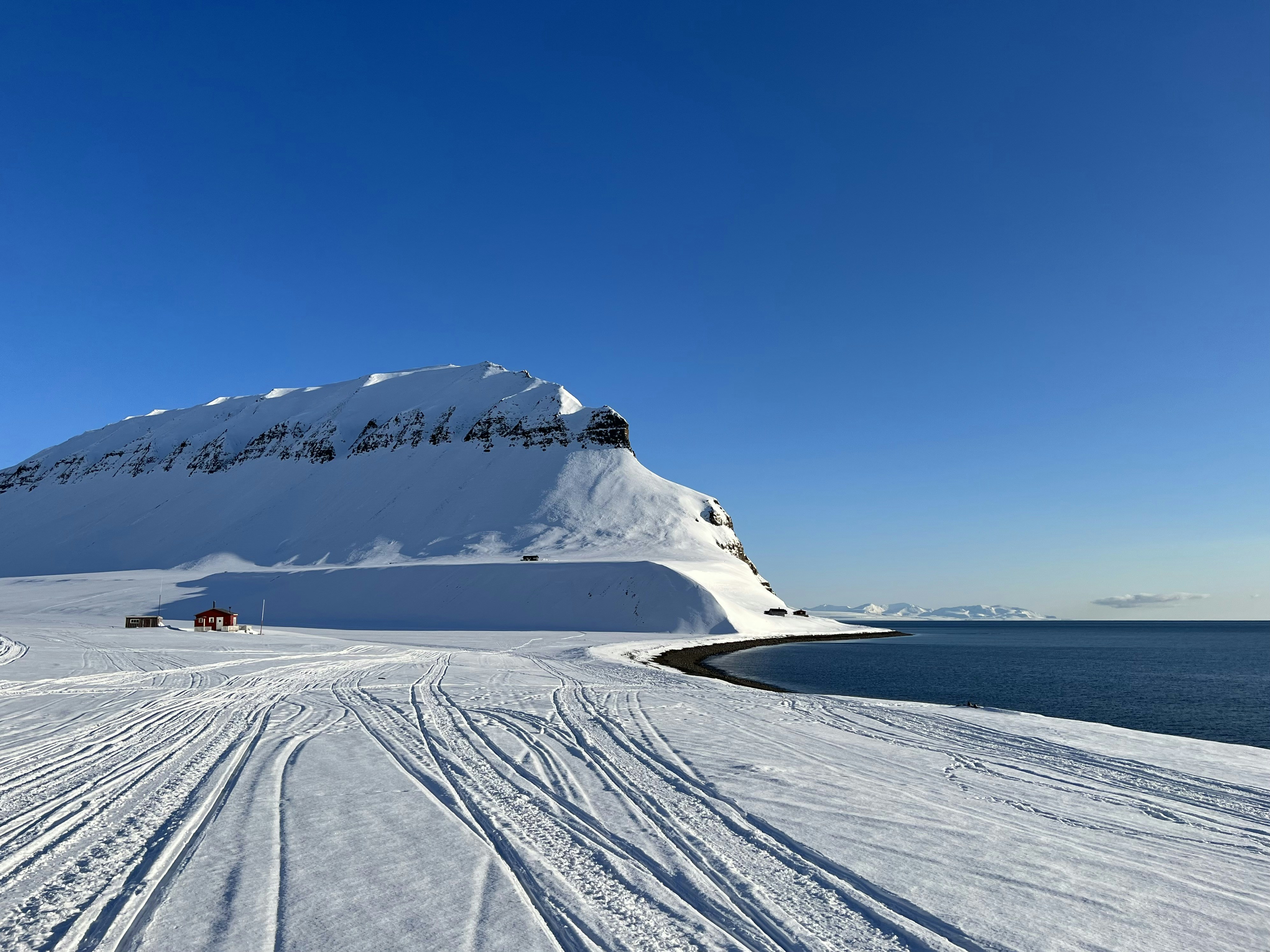 Red Cabin at a Snowbound Promontory Under a Pristine Arctic Sky