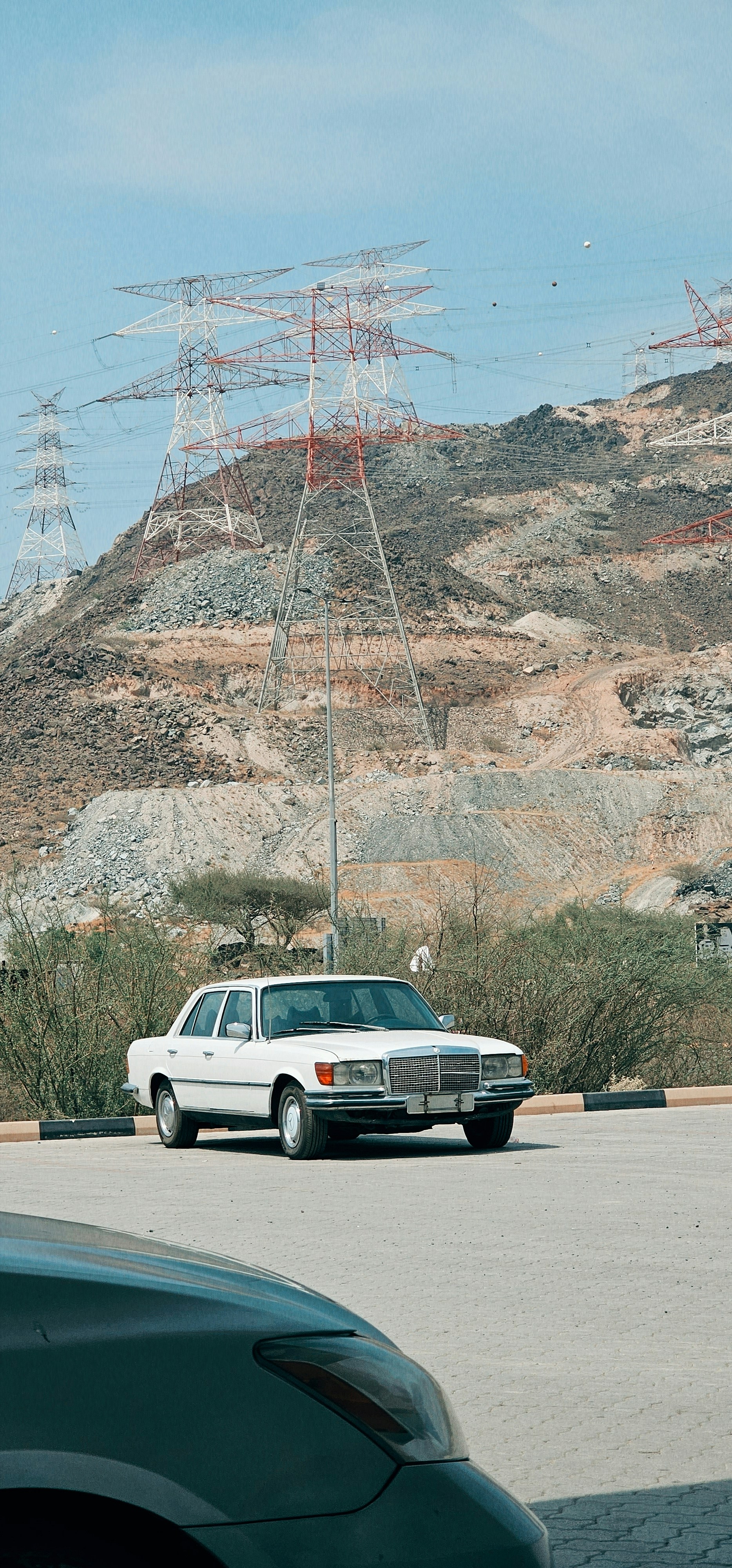 Vintage Mercedes Under a Lattice of Towers