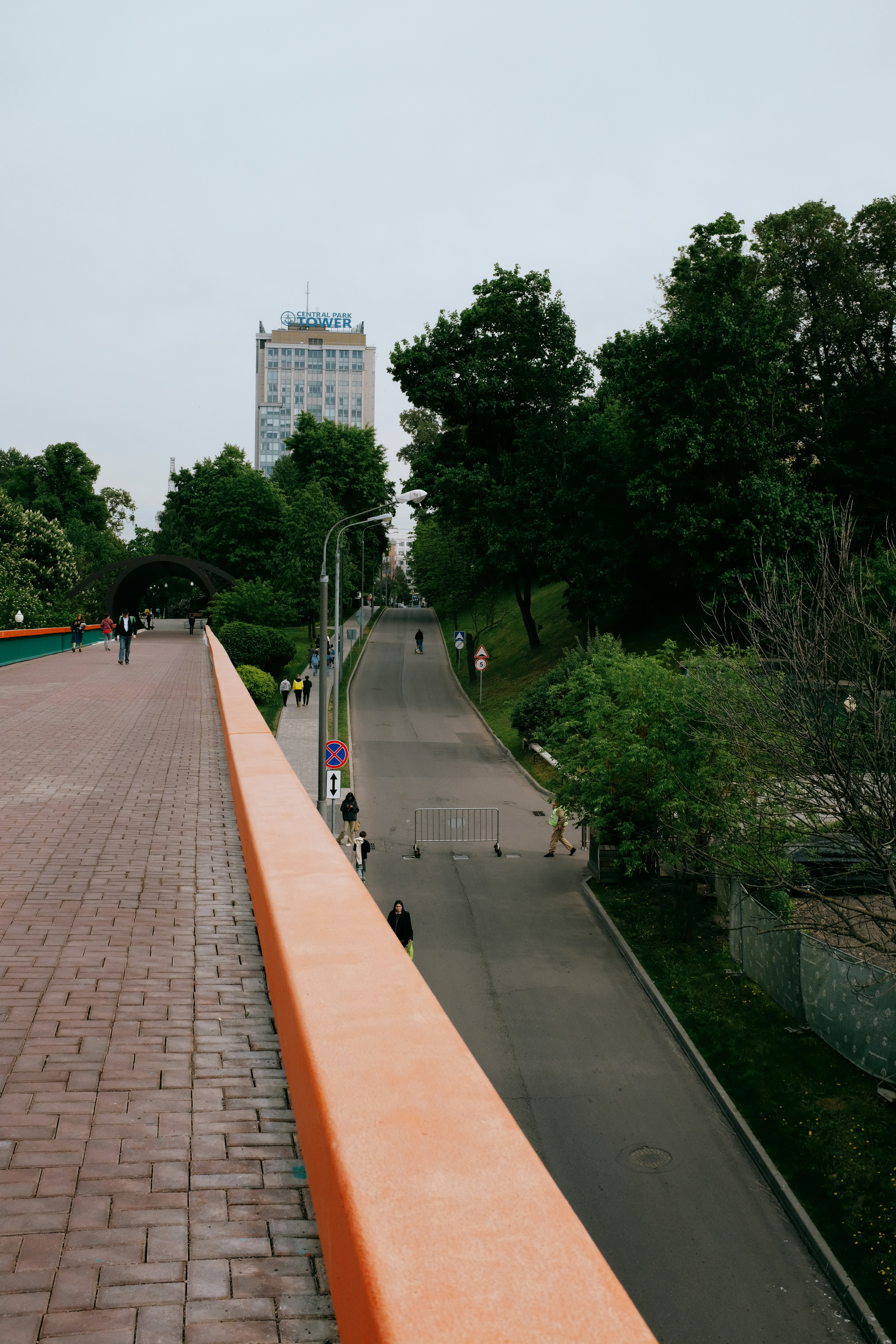Orange Railing, Green Corridor: A Quiet Ascent Toward the Distant Tower