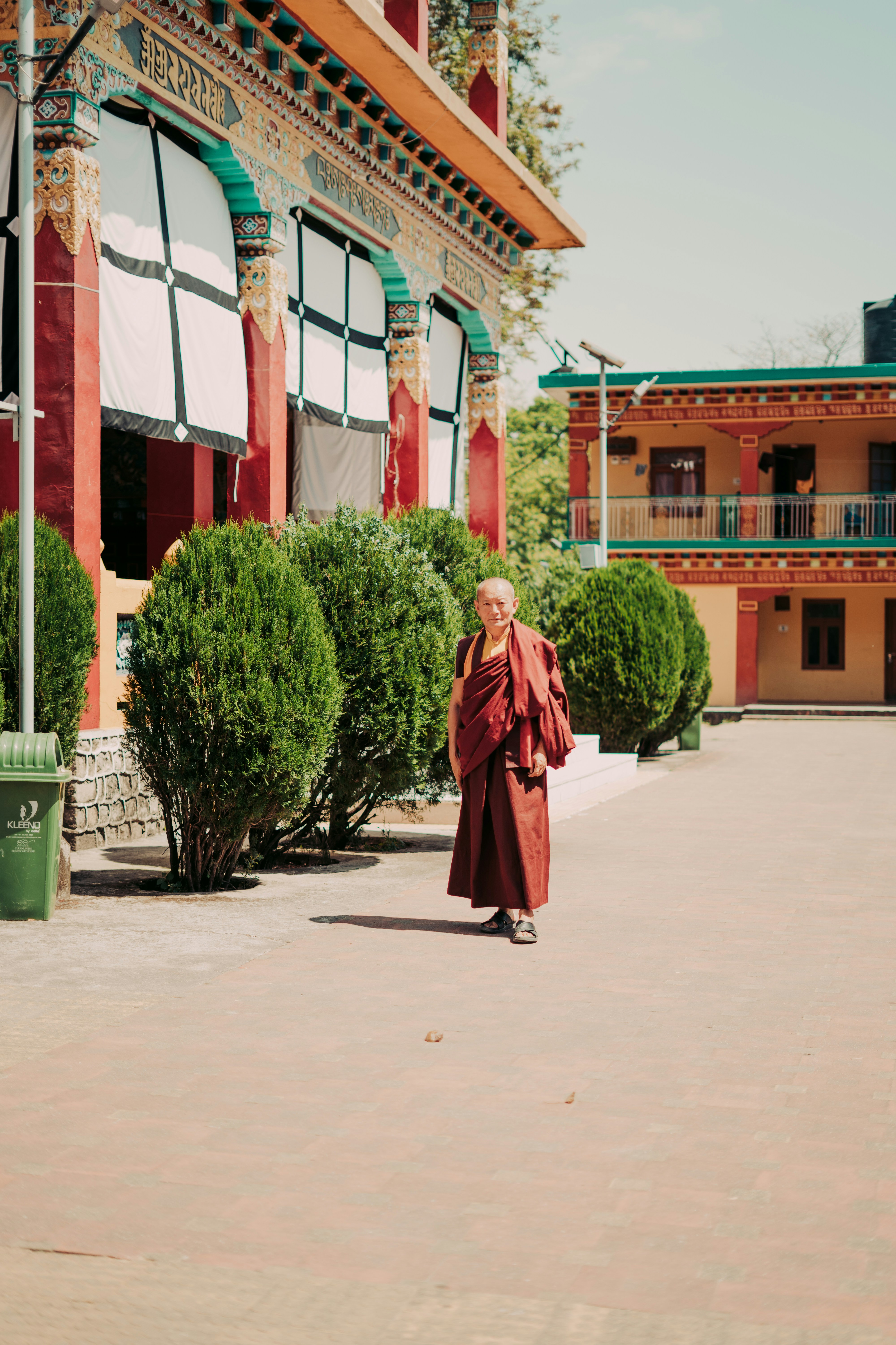 Red Robes, Quiet Steps: A Monk Traverses a Colorful Temple Courtyard