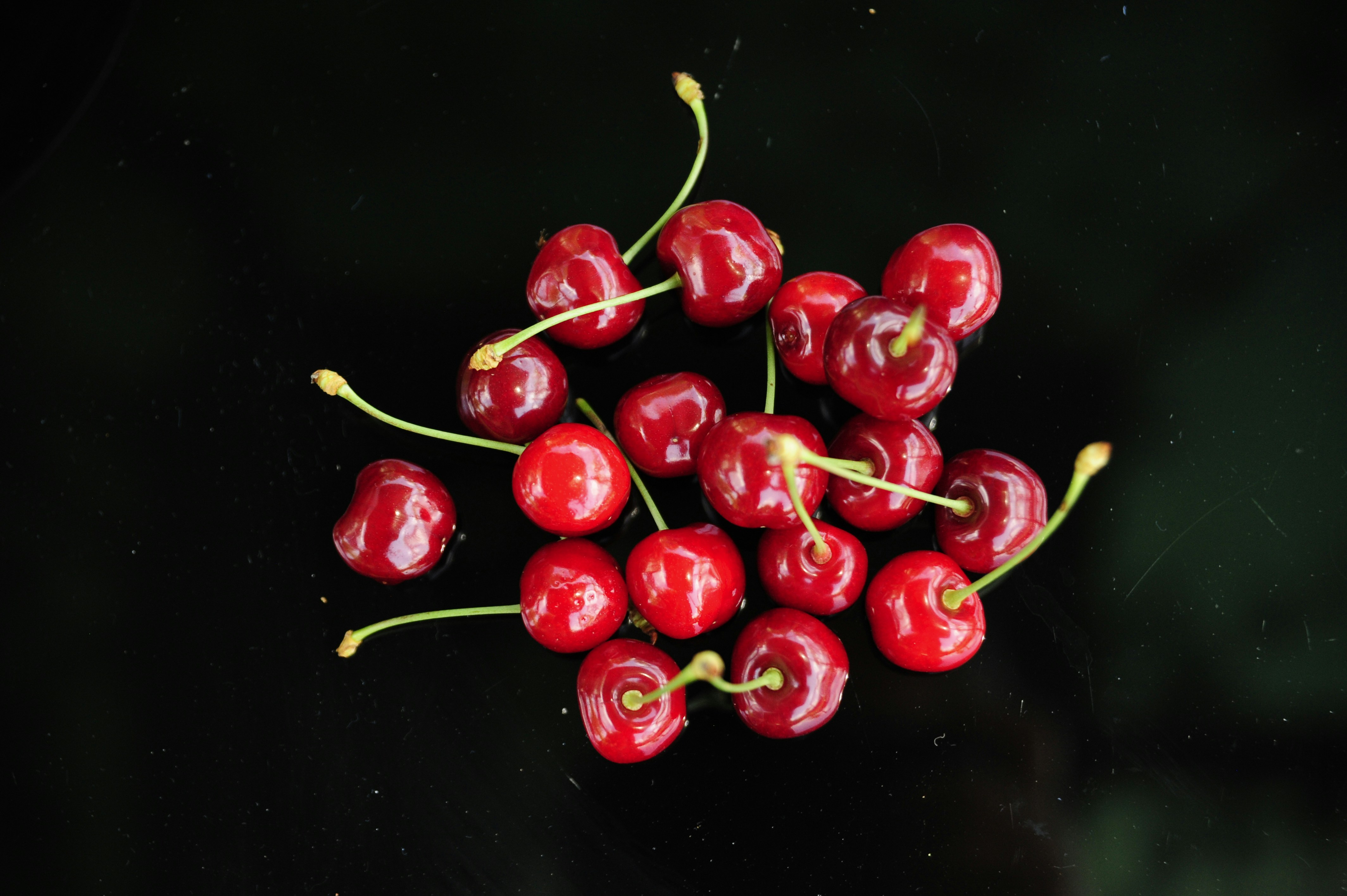 Crimson Cherries Congregate on a Velvet-Black Stage