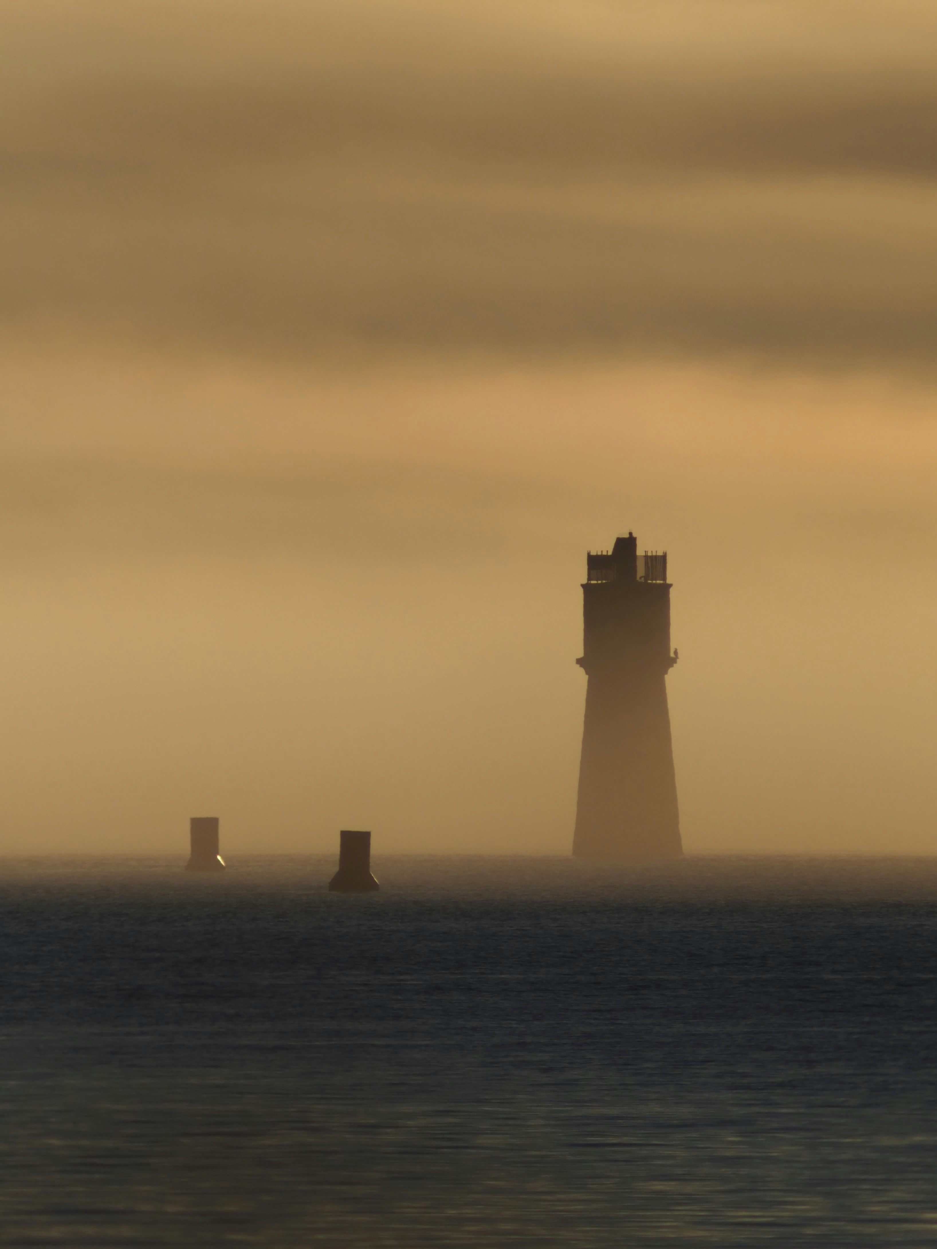 Amber Sentinel: Dusk Lighthouse in a Golden Haze