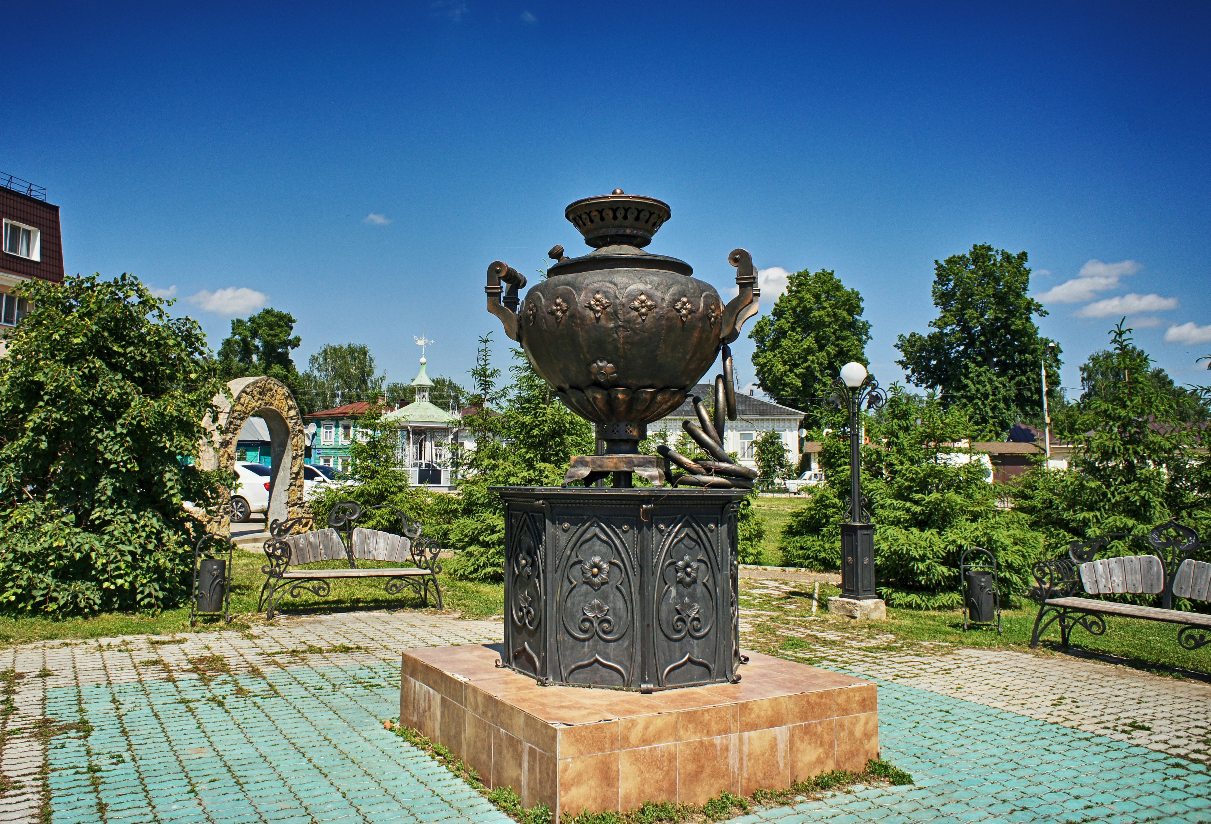 The sculptural composition forged samovar with bagels was installed in 2008 in front of the hotel "Toima". The author of the monument is Almaz Khakimov. | a large vase sitting on top of a stone pedestal