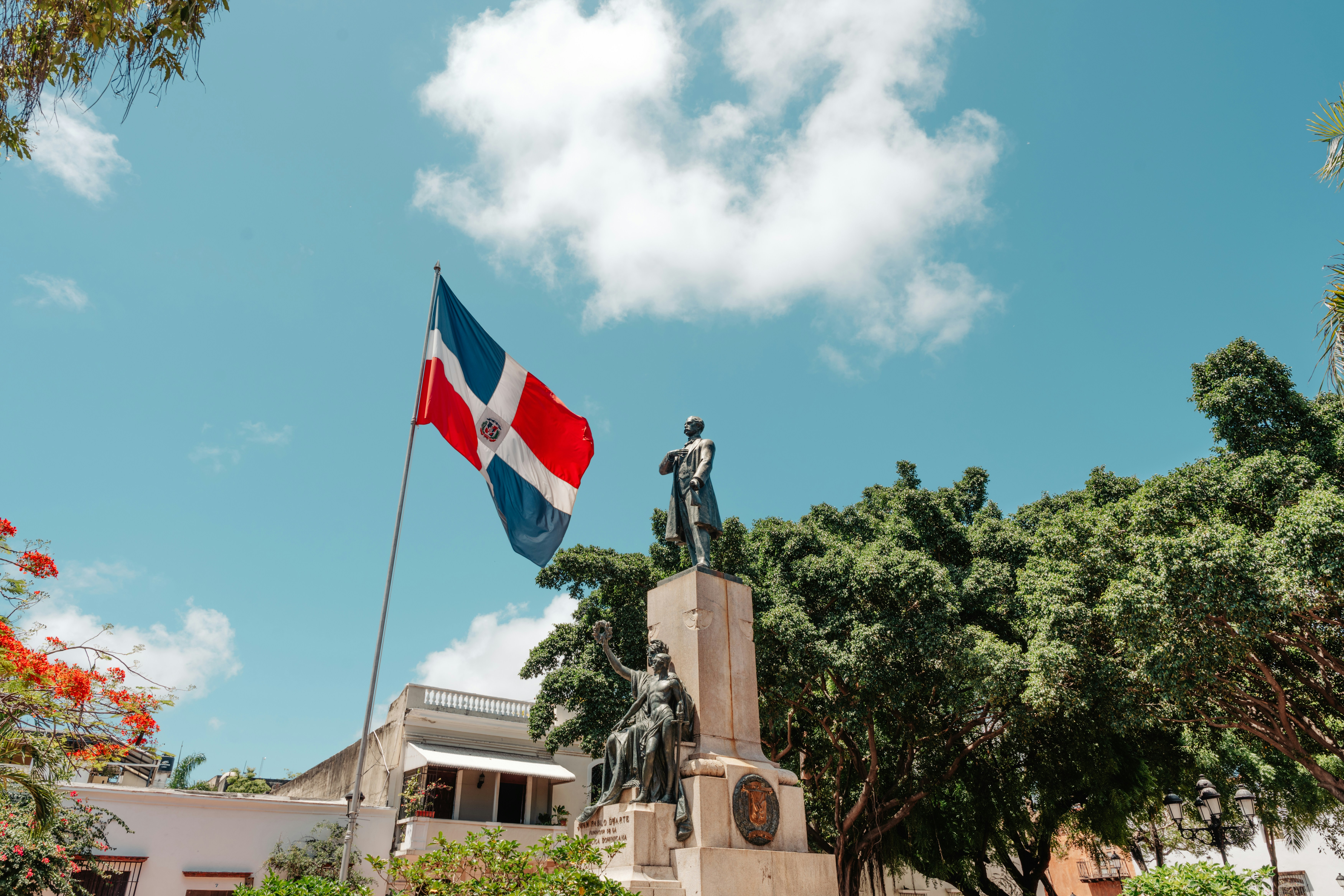 A statue of a man holding a flag in front of a building photo – Free ...
