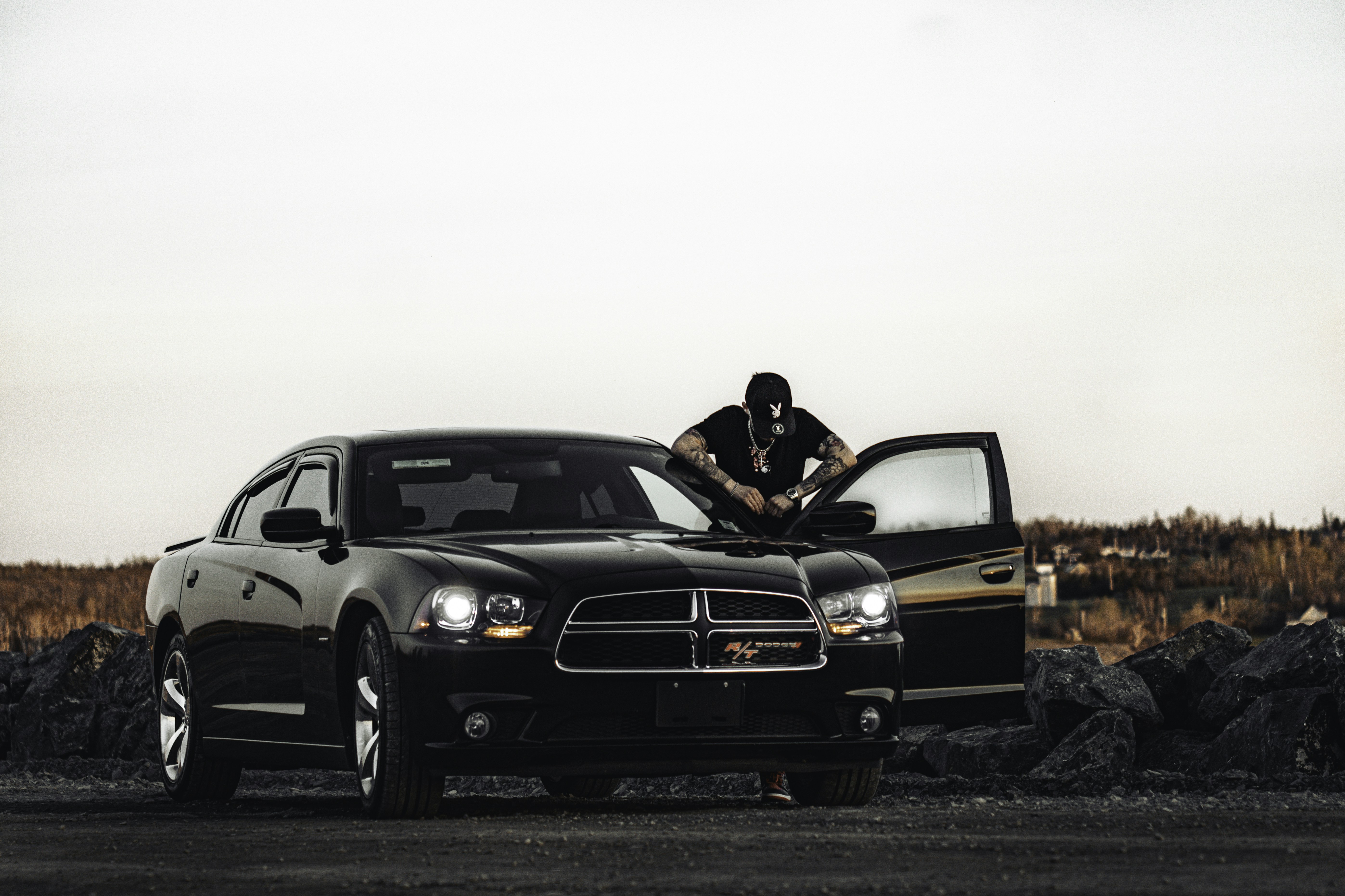 Desert Standstill: Two Figures at a Black Charger by a Rocky Horizon