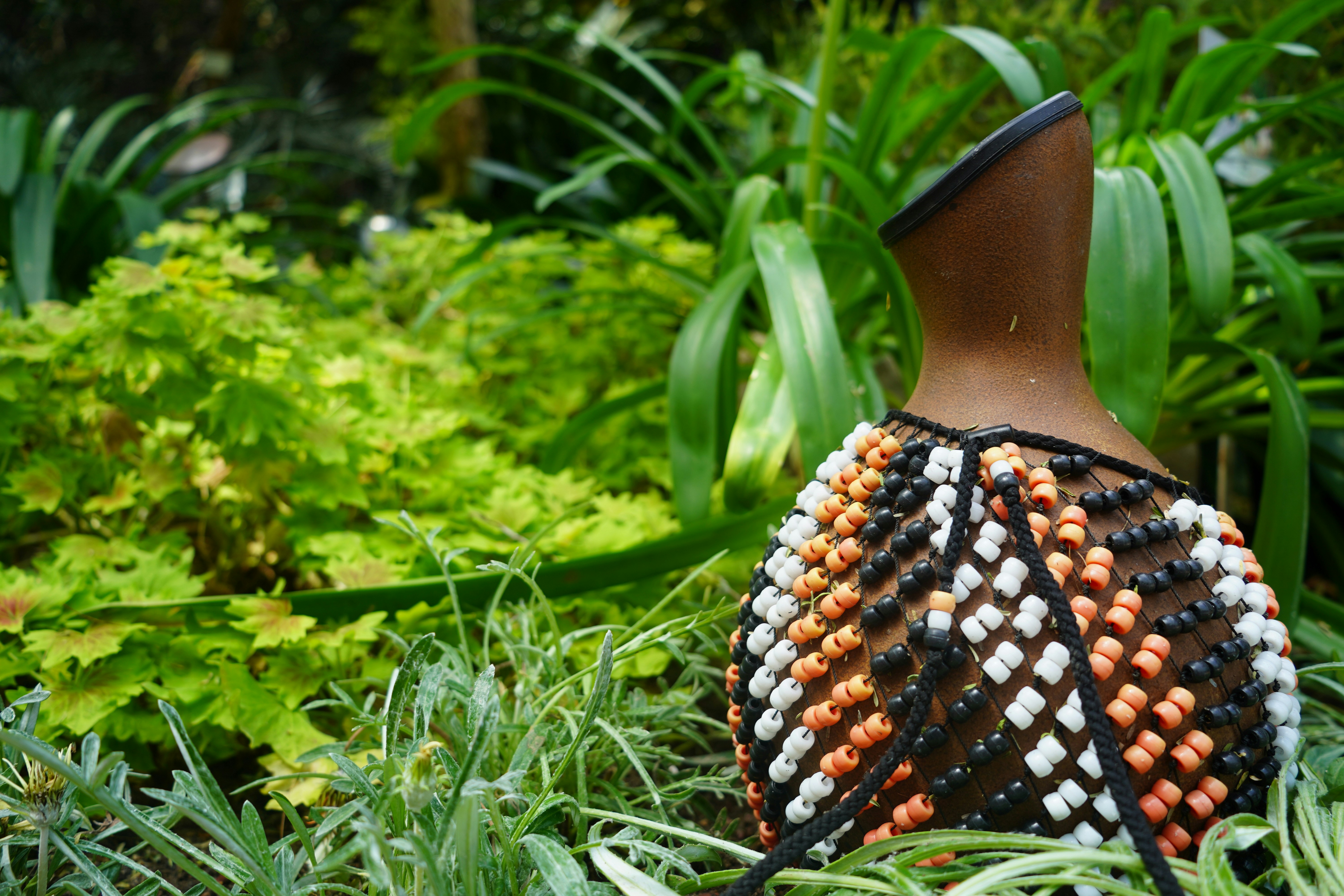 Beaded Bust Emerges from a Lush Garden