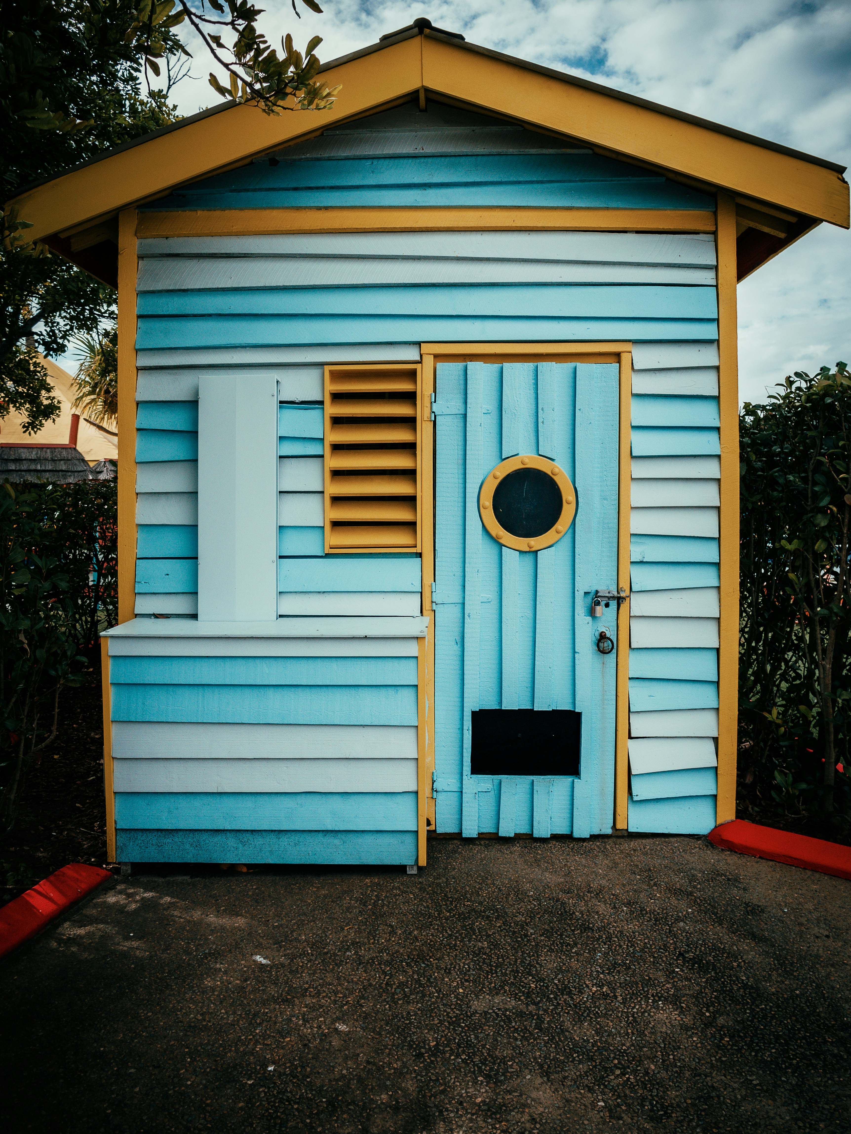 Porthole Door Beach Hut: A Bright Blue Retreat with Canary Trim