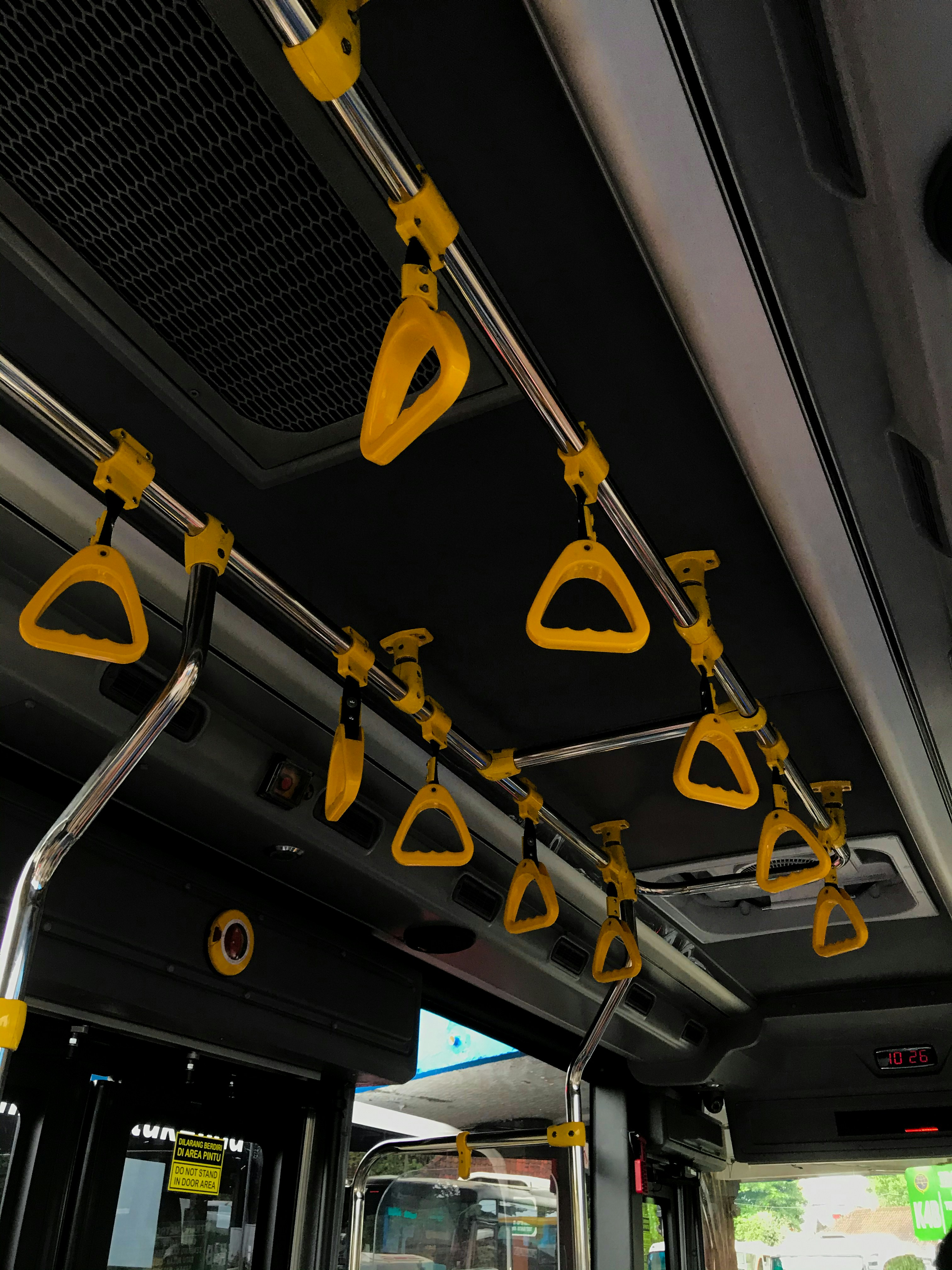 The interior of a public transit bus with yellow handrails photo – Free ...