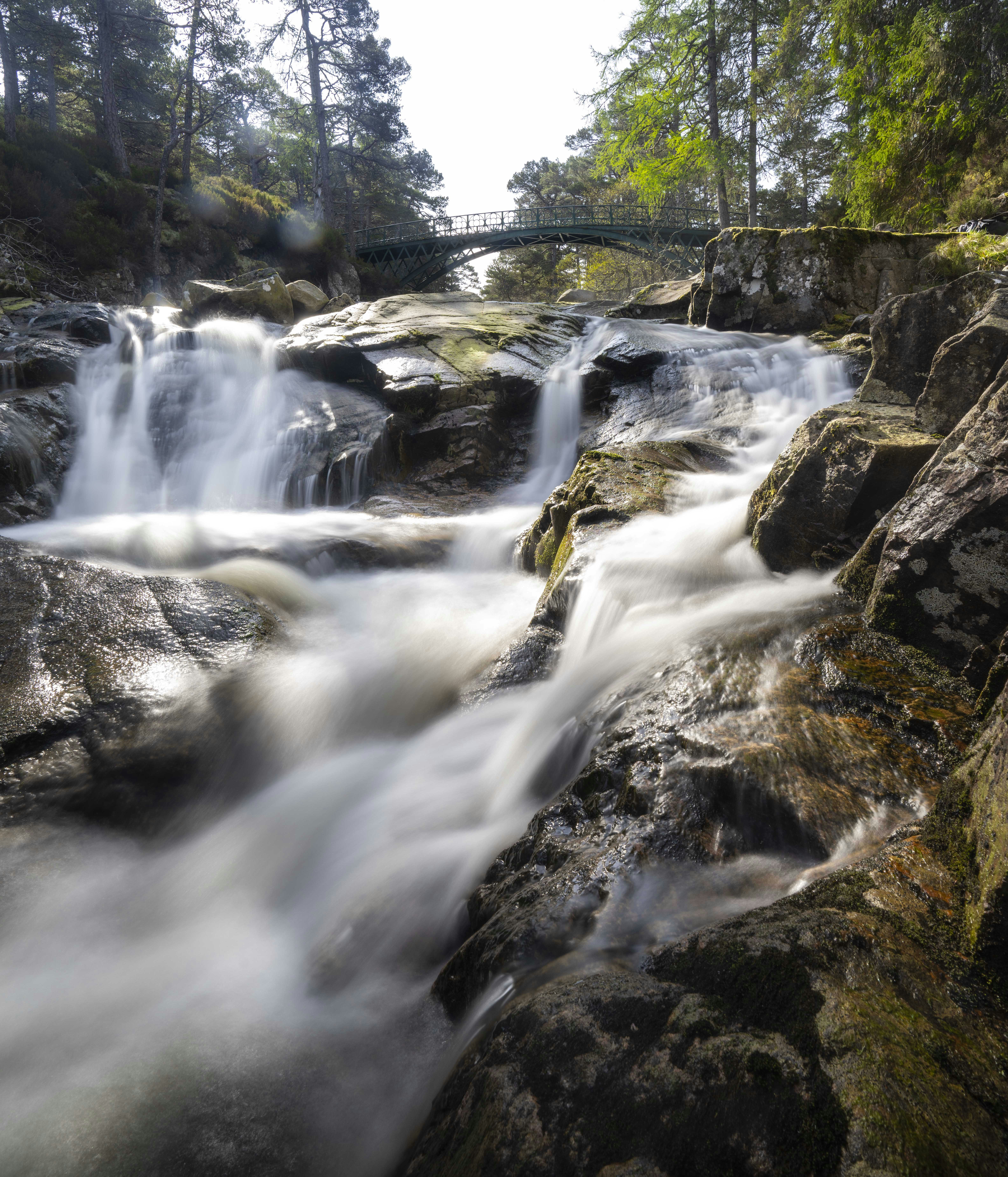 A waterfall flowing over rocks into a river photo – Free Waterfall ...