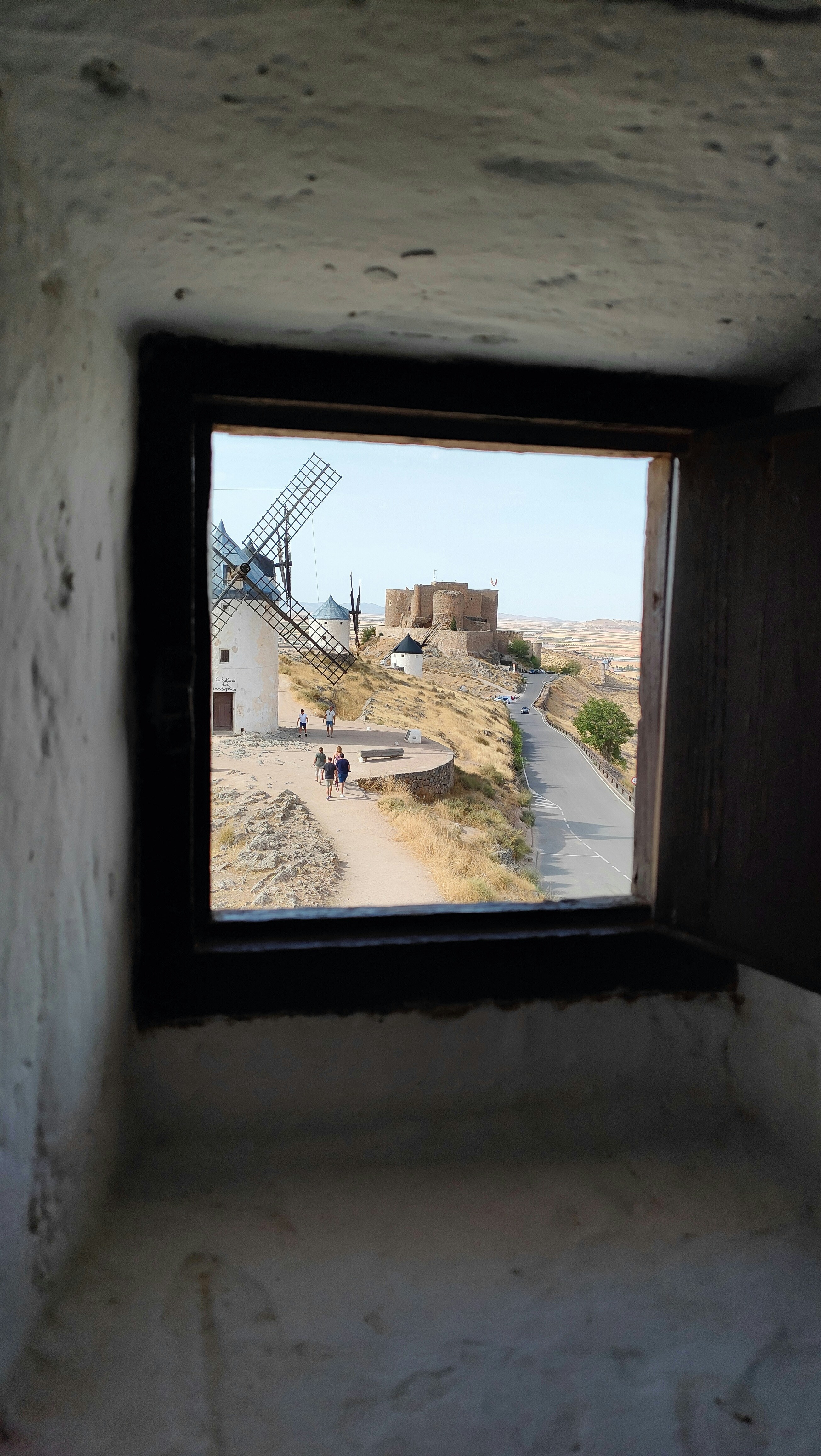 A window with a view of a windmill photo – Free Consuegra Image on Unsplash