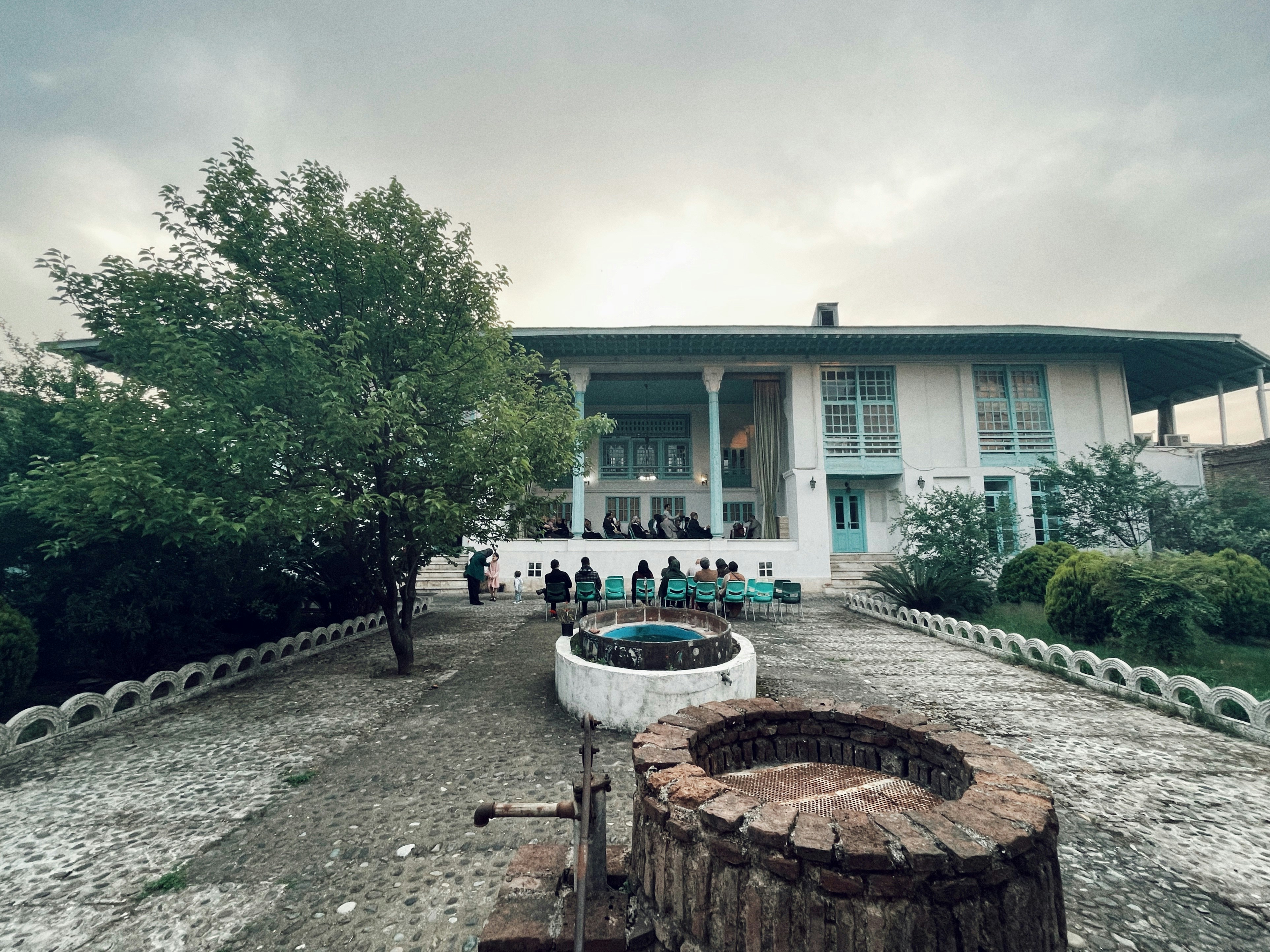 Veranda Assembly Before a Modern Campus, Framed by a Circular Brick Well